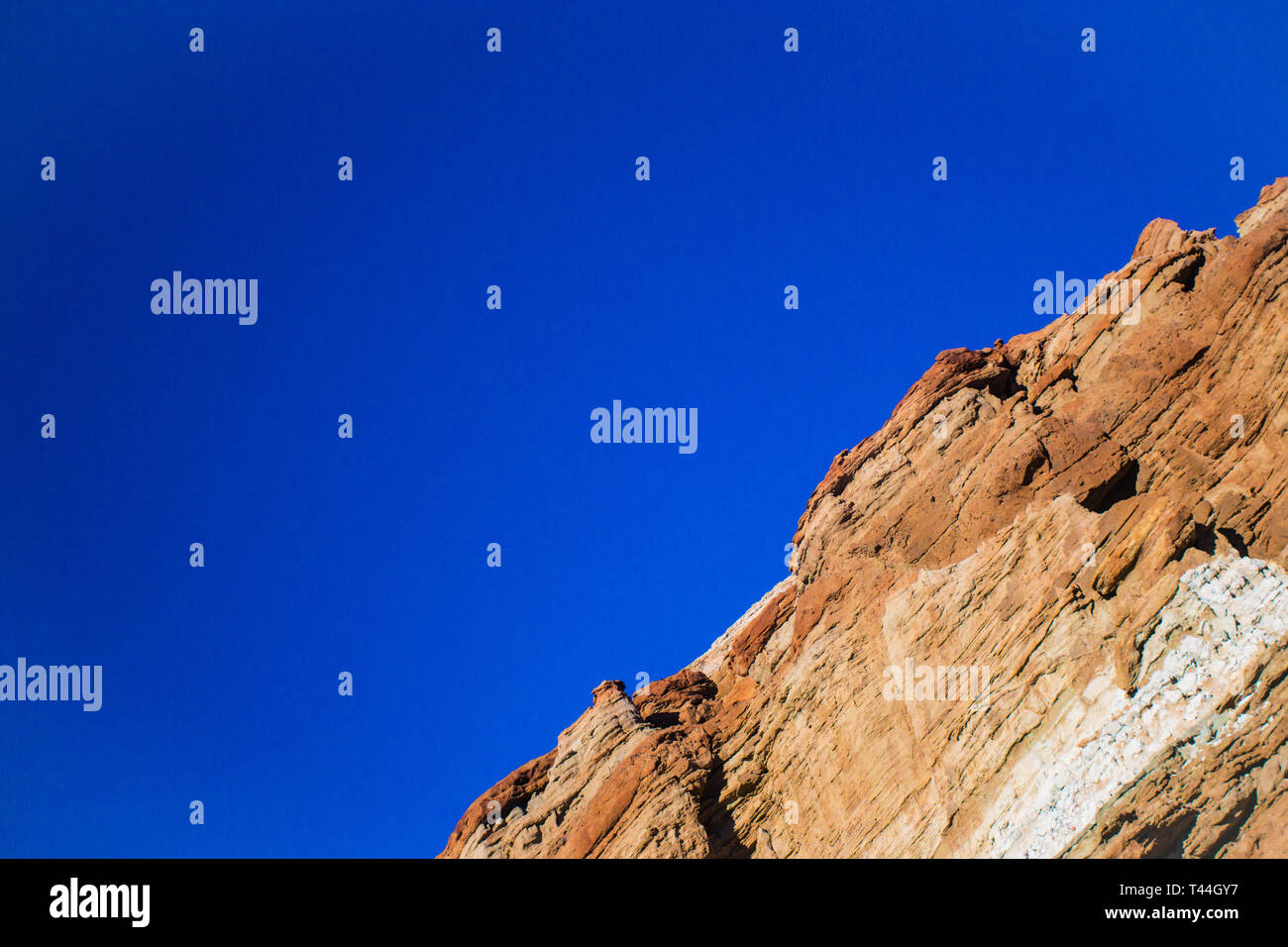 Diagonal rock angle of orange sedimentary cliff face above the mojave ...