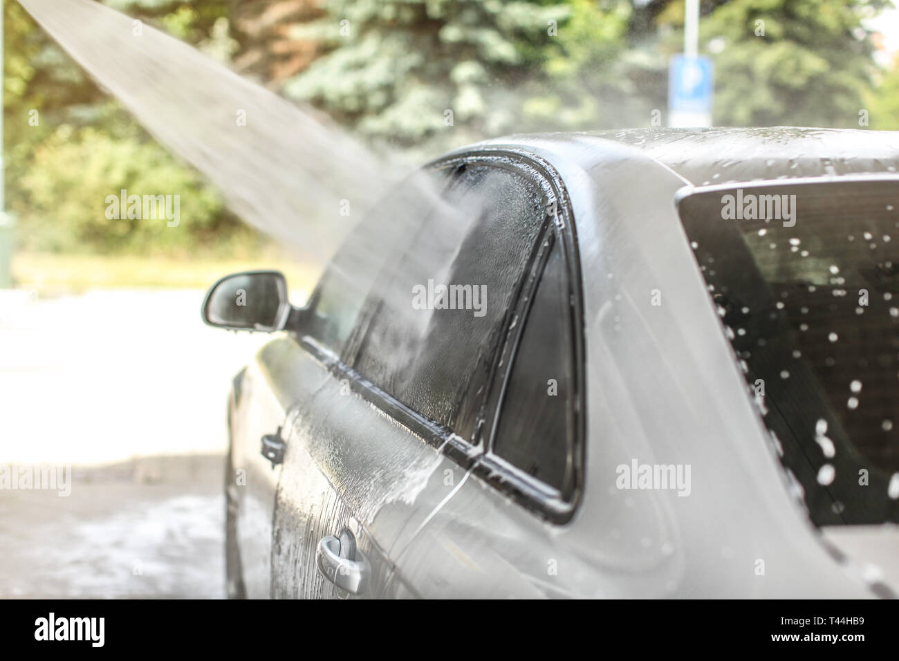 Side window of car washed in self serve carwash, high pressure jet ...