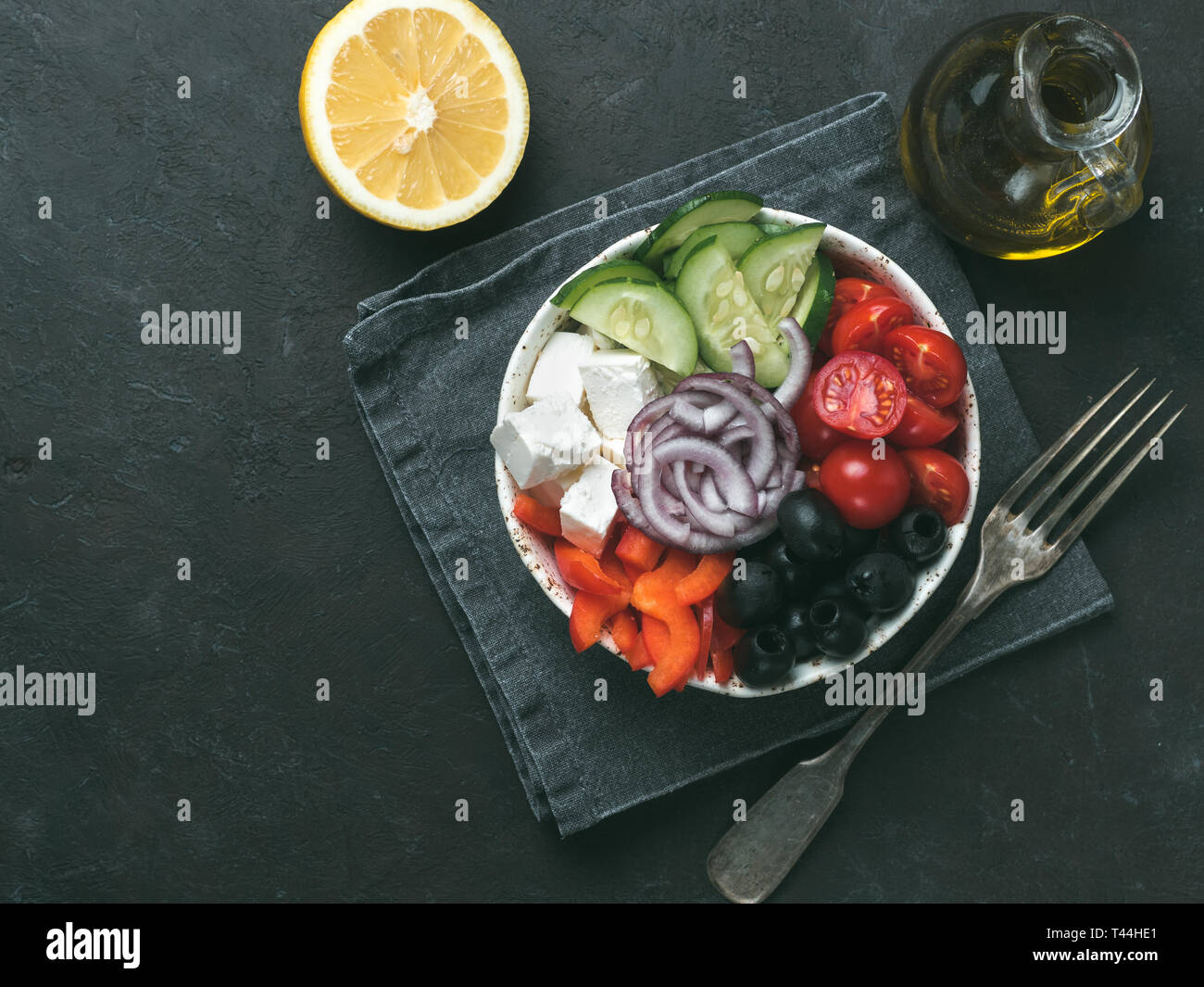 Greek Salad Bowl on dark black background, copy space. Above view of ...