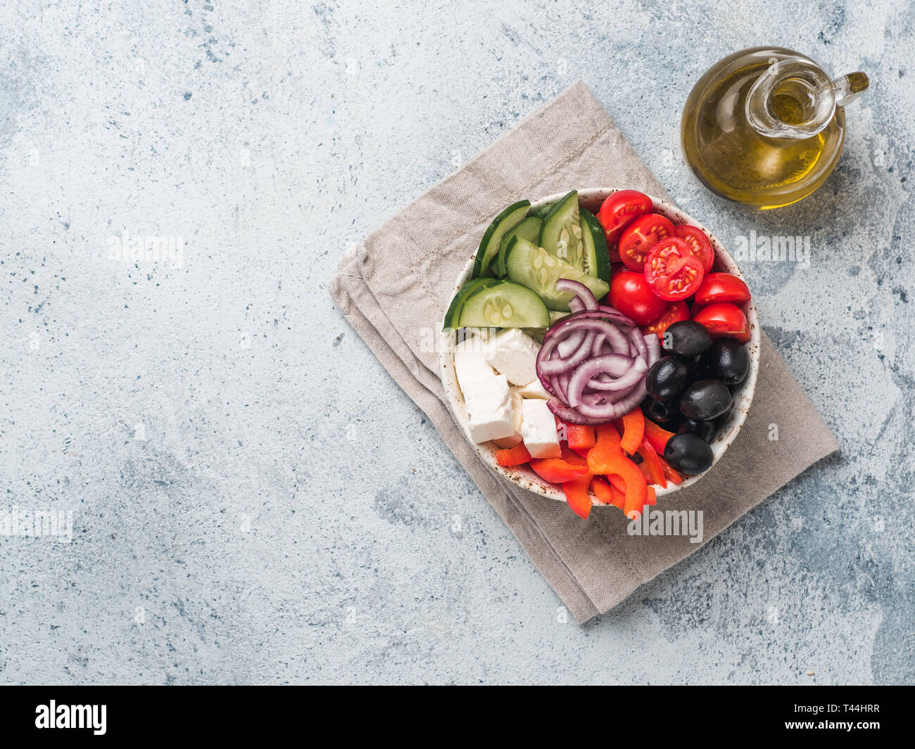 Greek Salad Bowl on gray cement background, copy space. Above view of ...