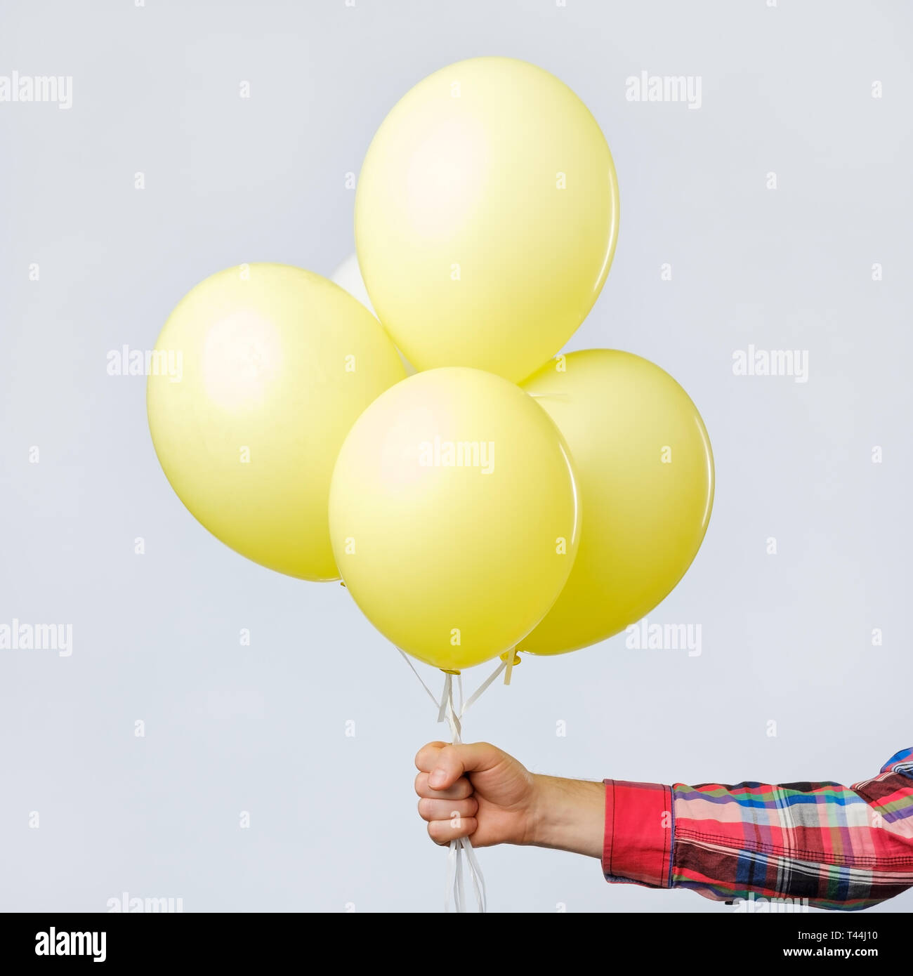 Yellow air flying balloons in man hands isolated on white background ...