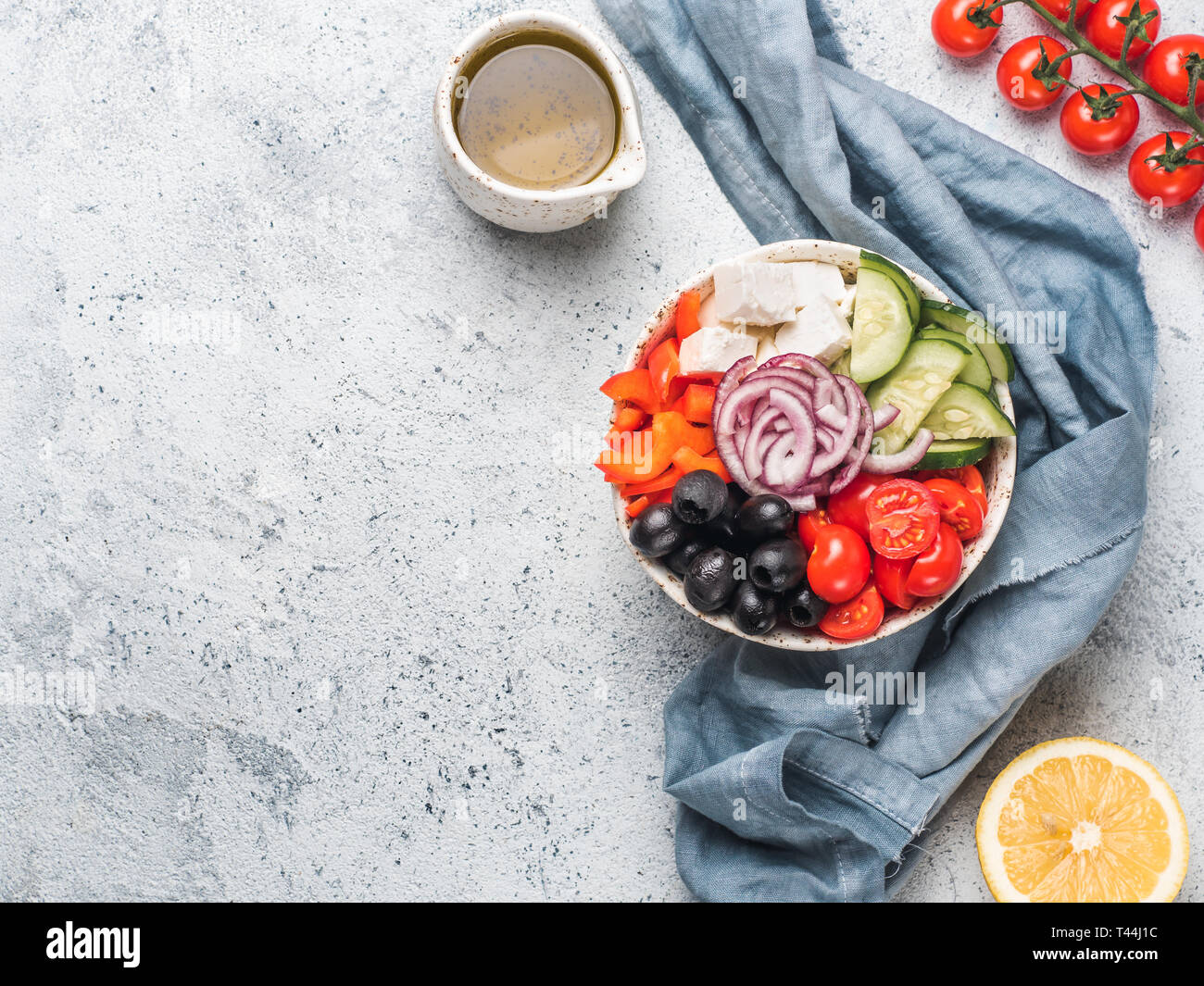 Greek Salad Bowl on gray cement background, copy space. Above view of ...