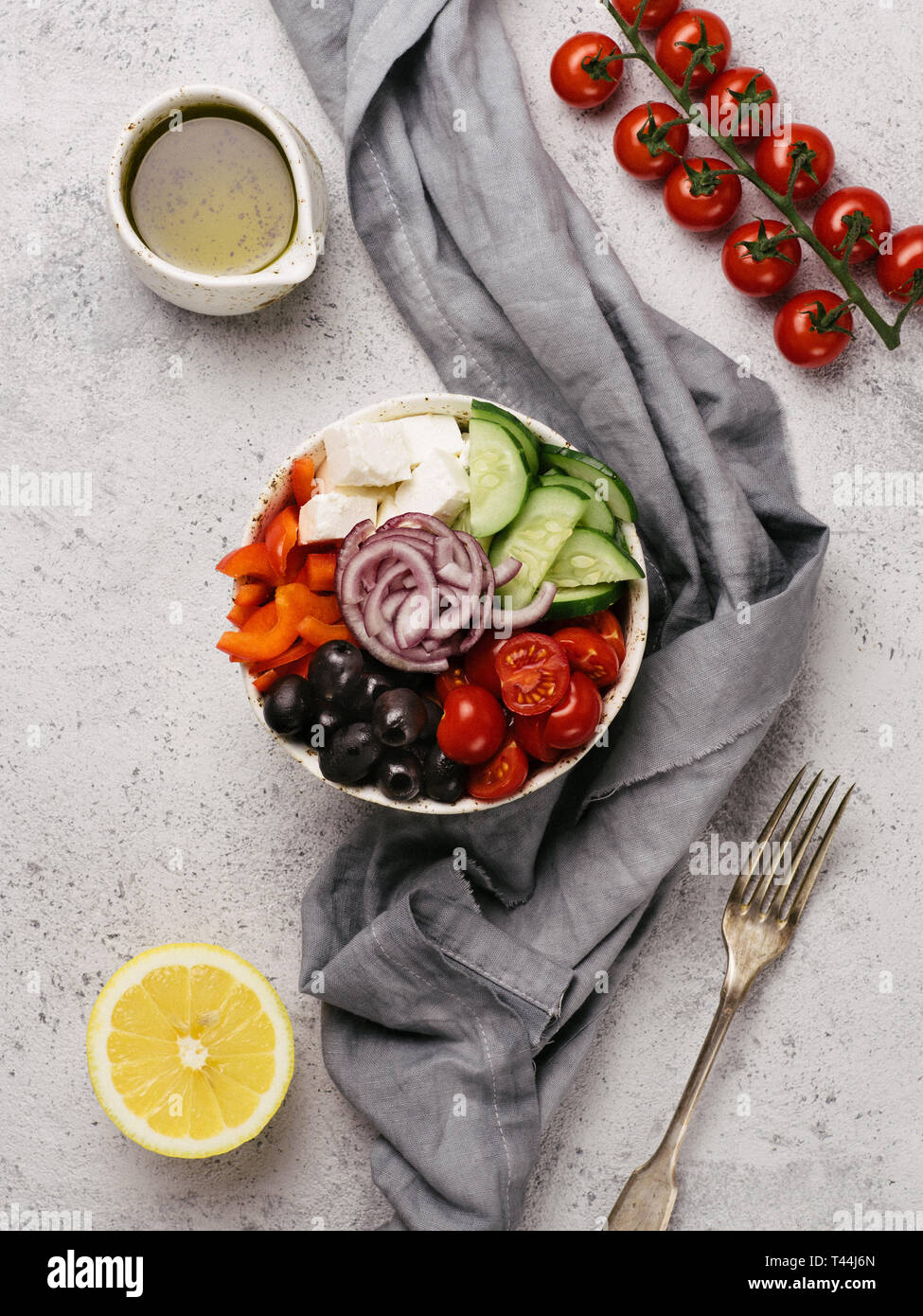 Greek Salad Bowl on gray cement background, copy space. Above view of ...