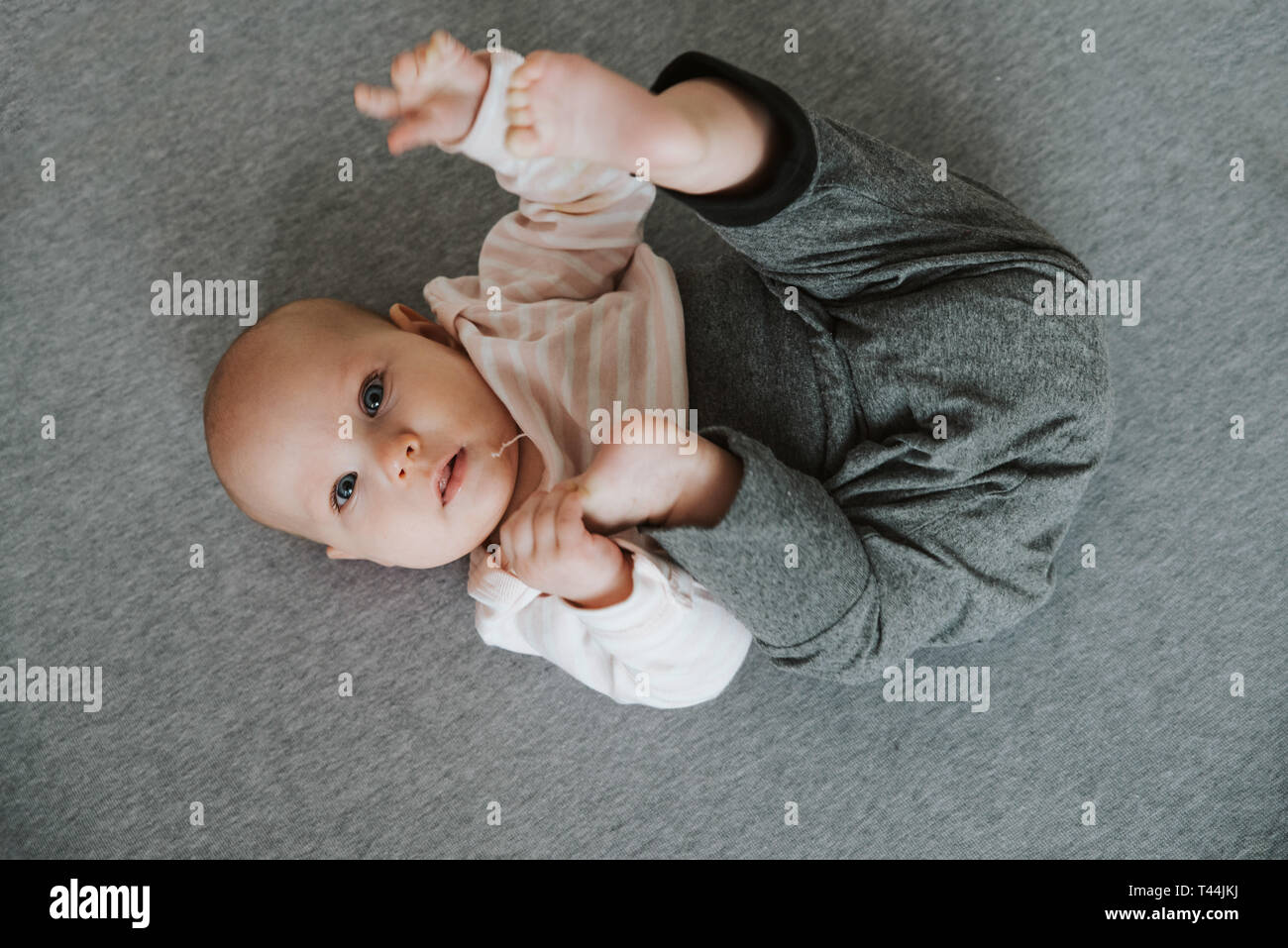 newborn stretching arms and legs on the floor, top view Stock Photo - Alamy