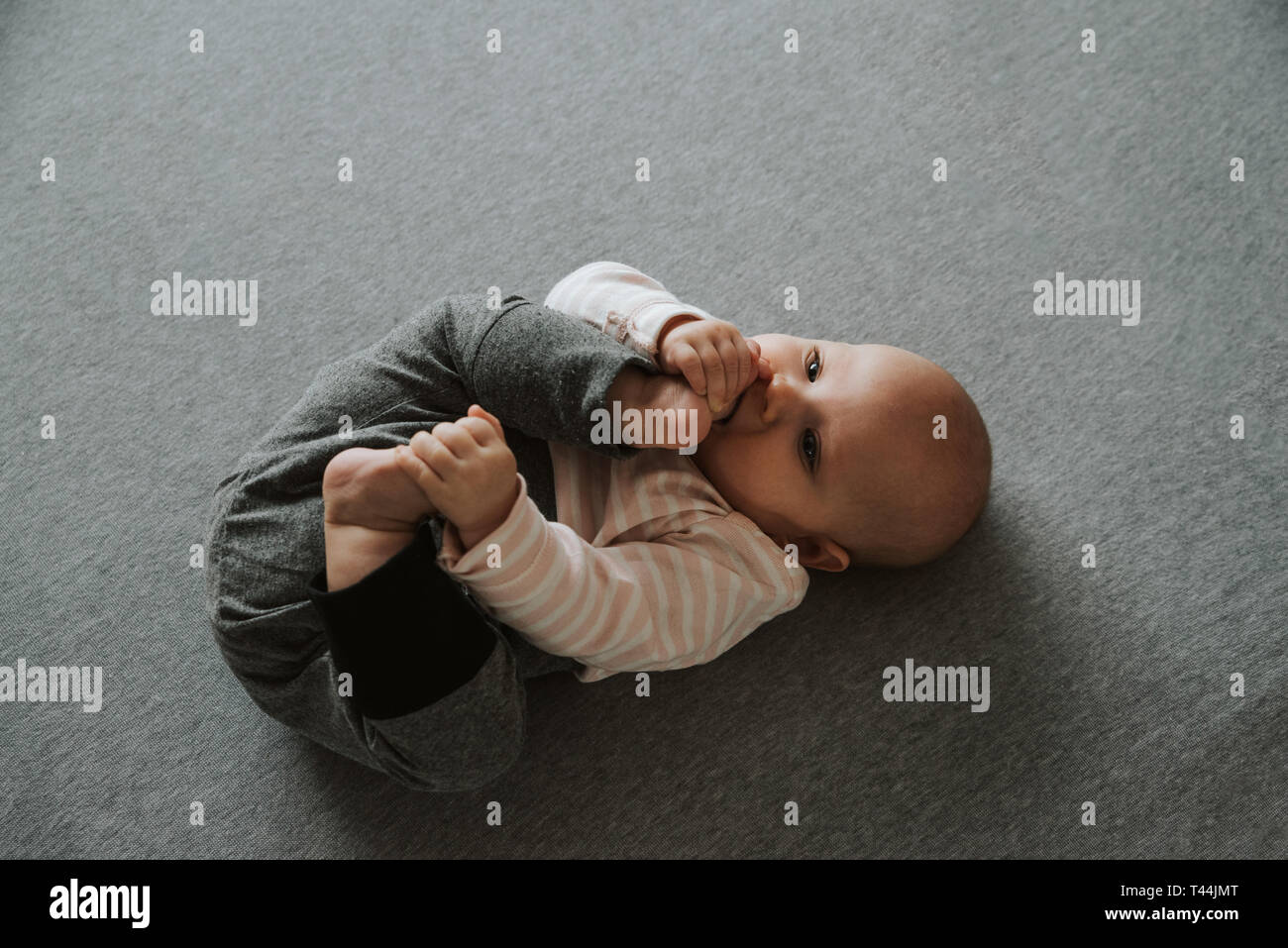 newborn stretching arms and legs on the floor, top view Stock Photo - Alamy