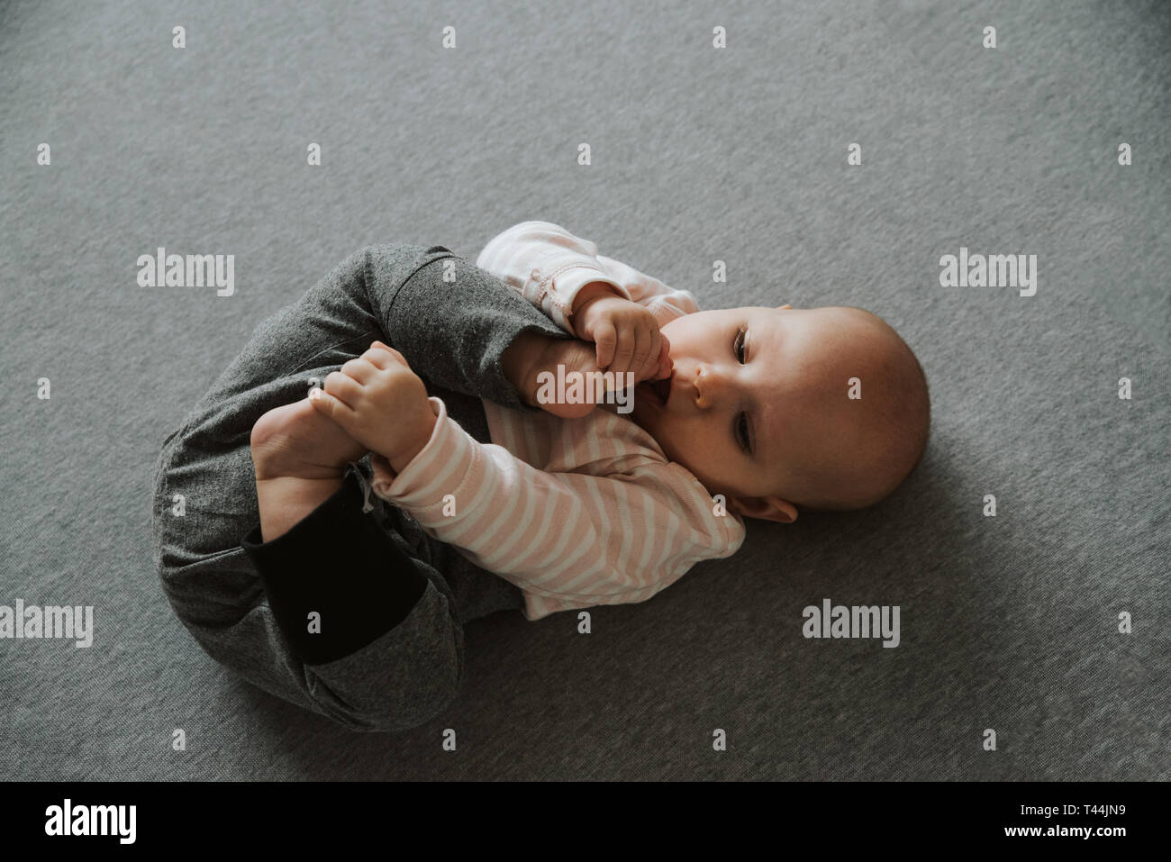 newborn stretching arms and legs on the floor, top view Stock Photo - Alamy