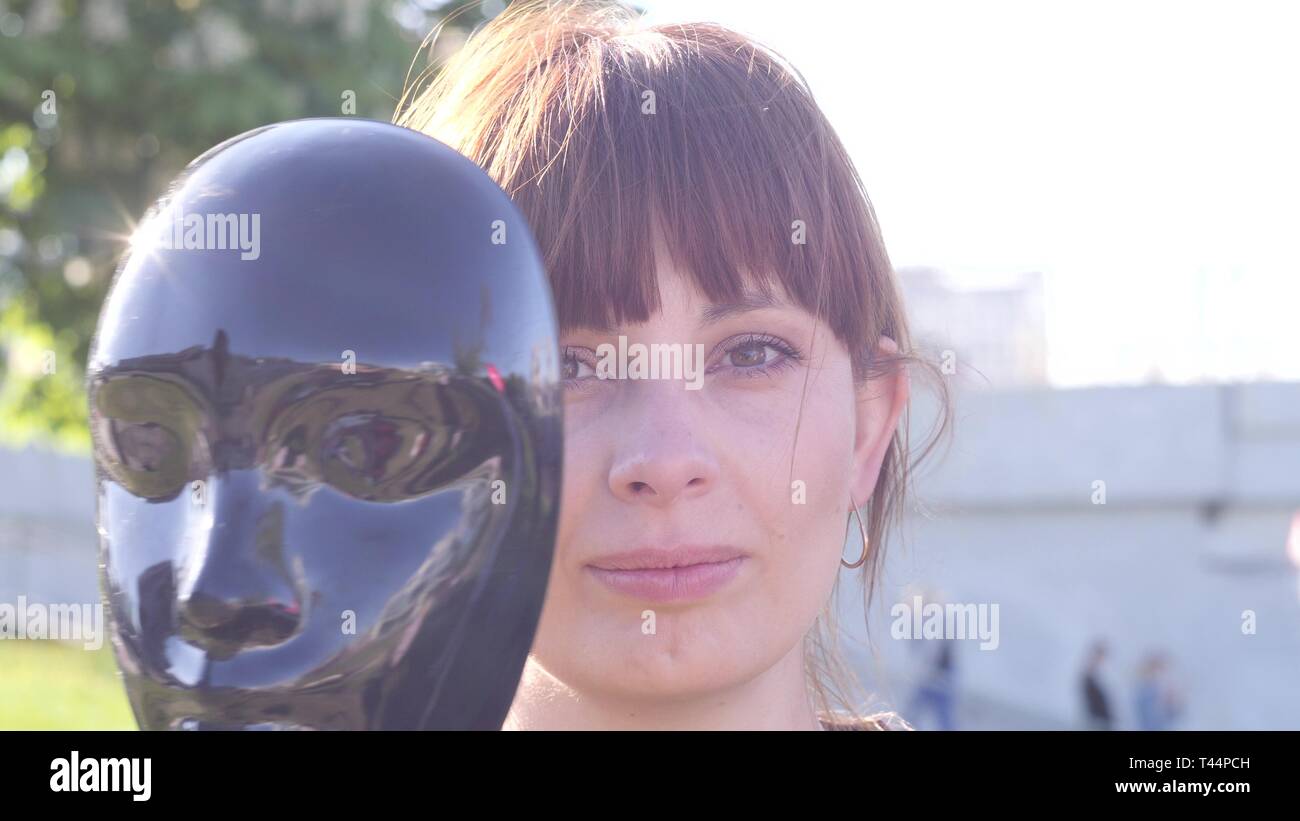 portrait of a young pretty charismatic woman who hiding her face behind ...