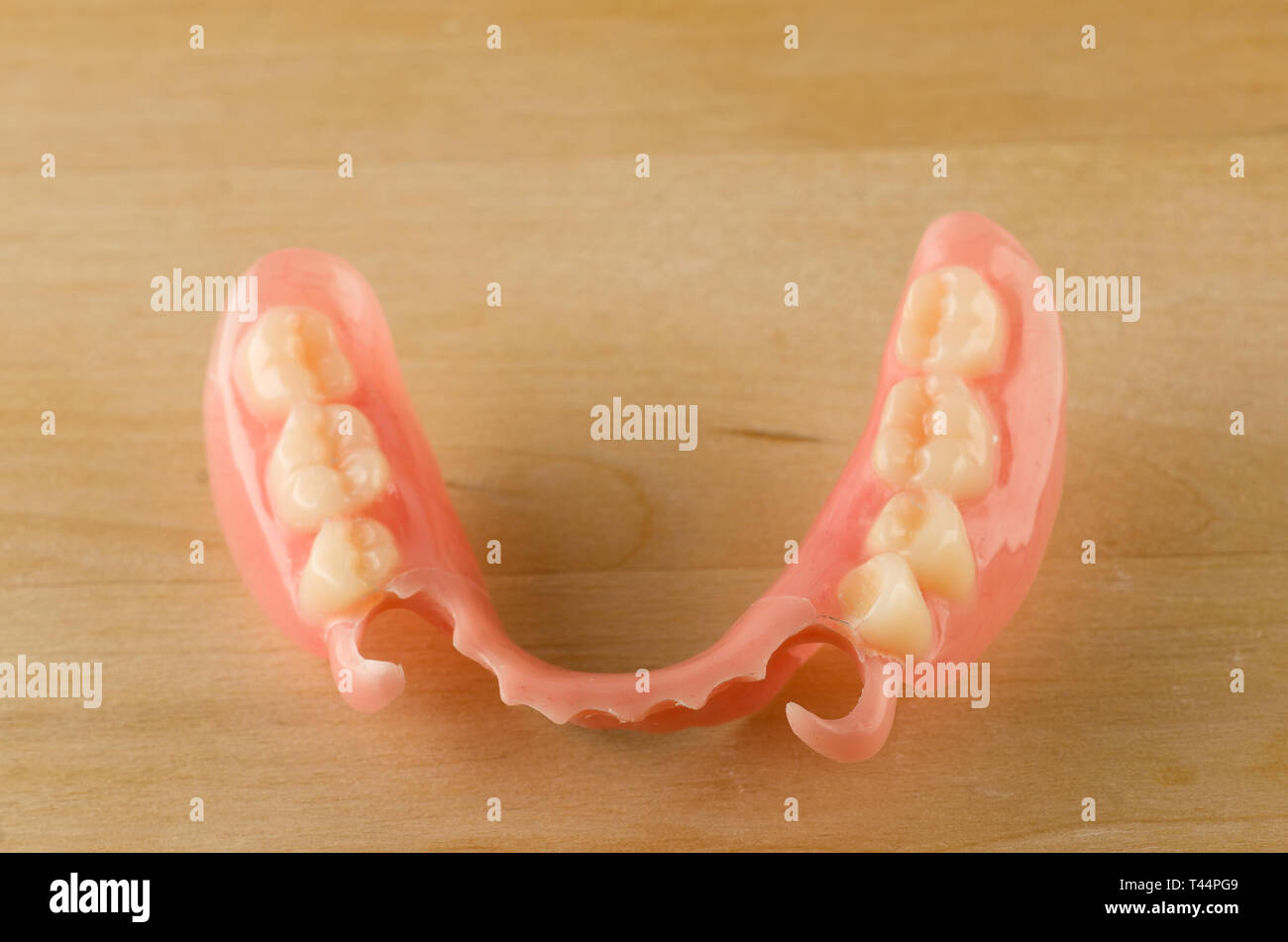 large image of a modern denture on a wooden background Stock Photo - Alamy