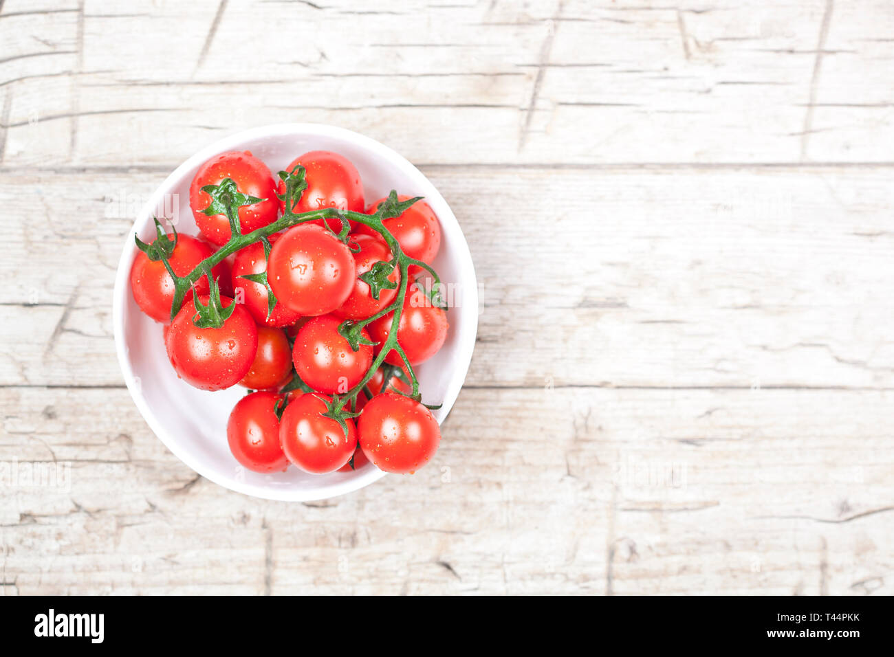 Fresh tomatoes in white bowl on rustic wooden table. Tomato, healthy ...