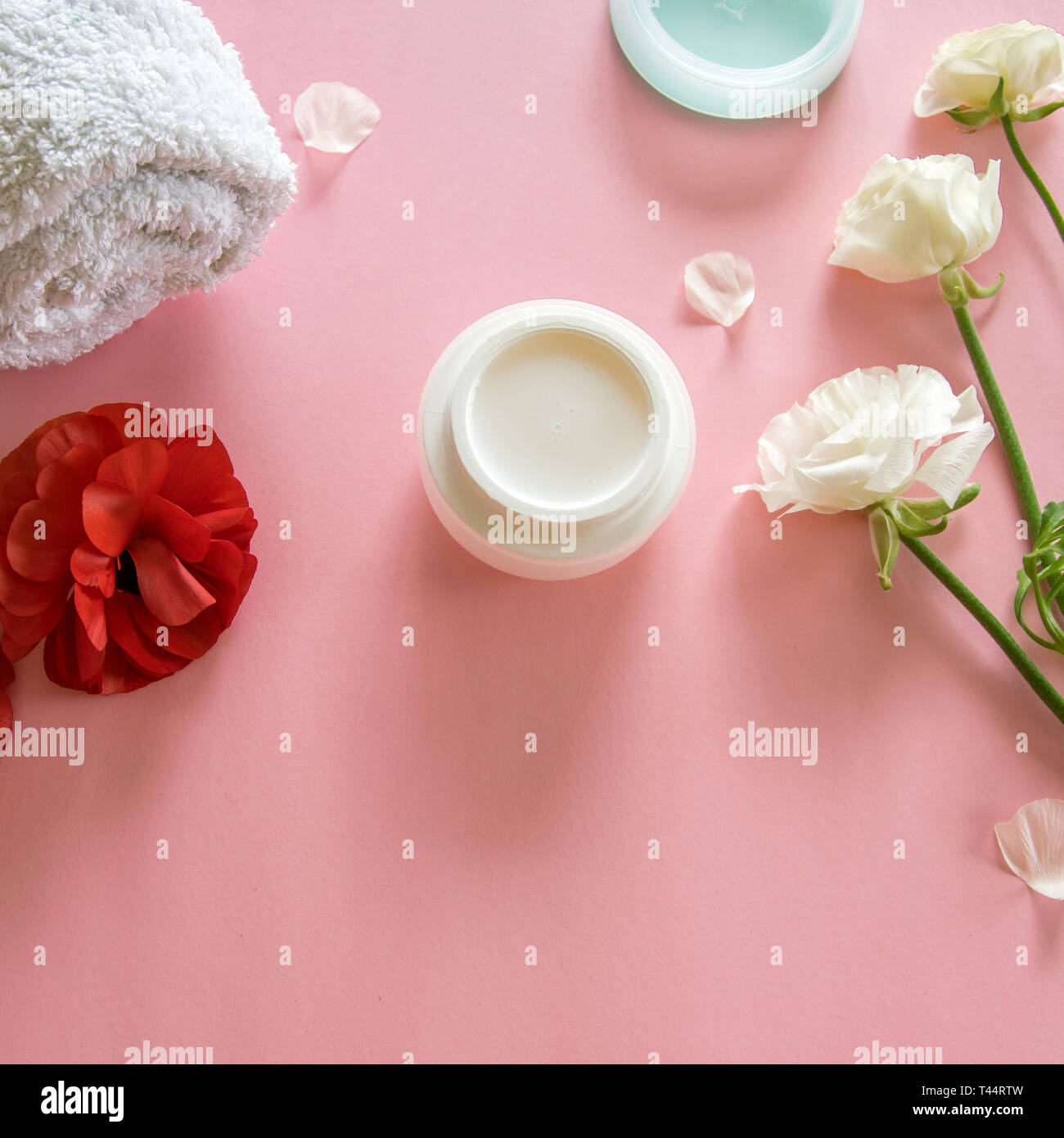 Organic skin care product and delicate flowers on pink background ...