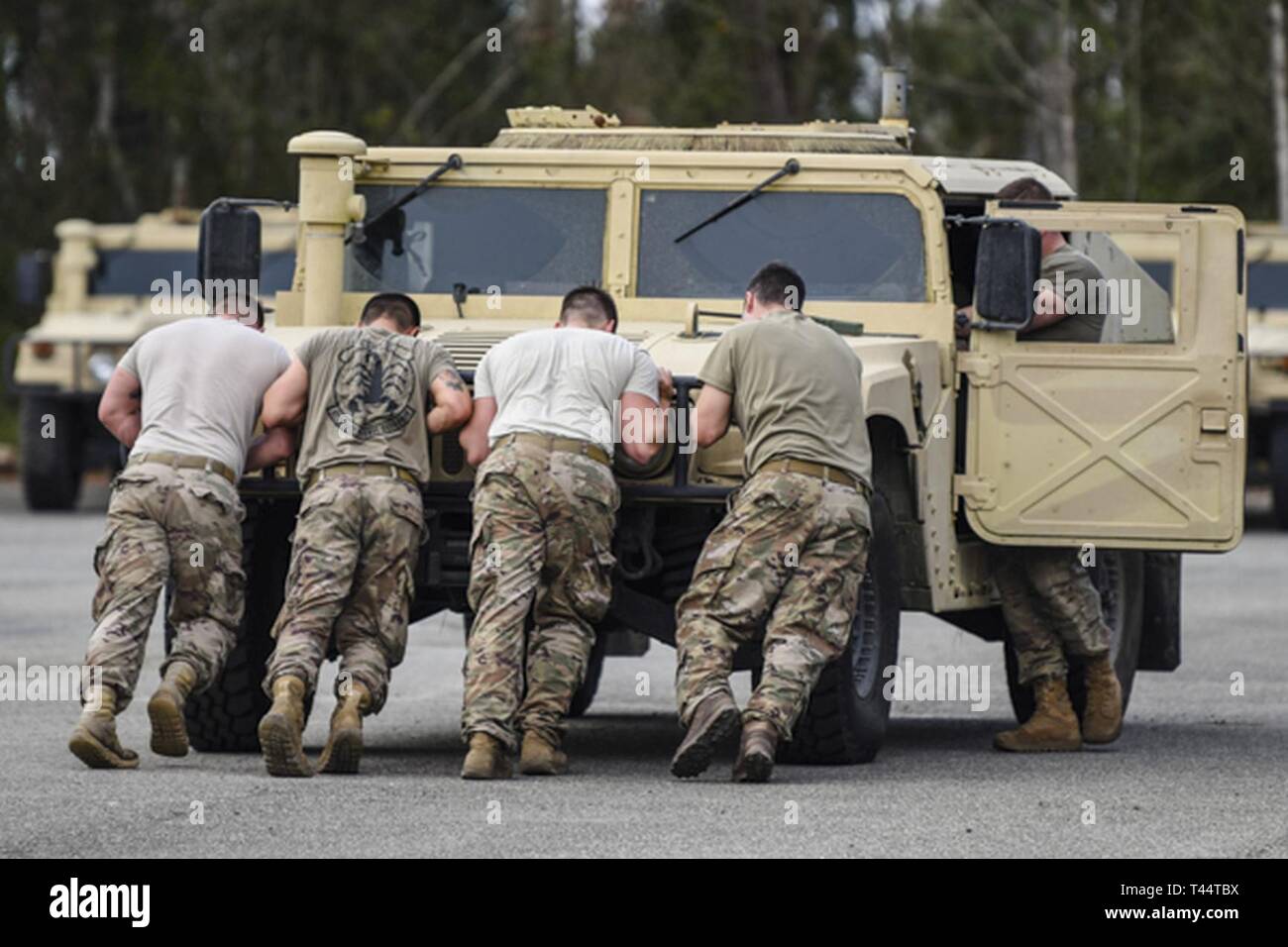 Airmen assigned to the 822d Base Defense Squadron push a Humvee during ...
