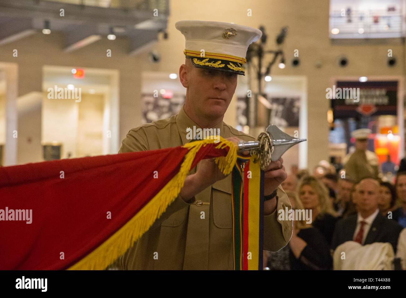 U.S. Marine Corps Lt. Col. Eric Grunke adds a ribbon to the unit colors ...