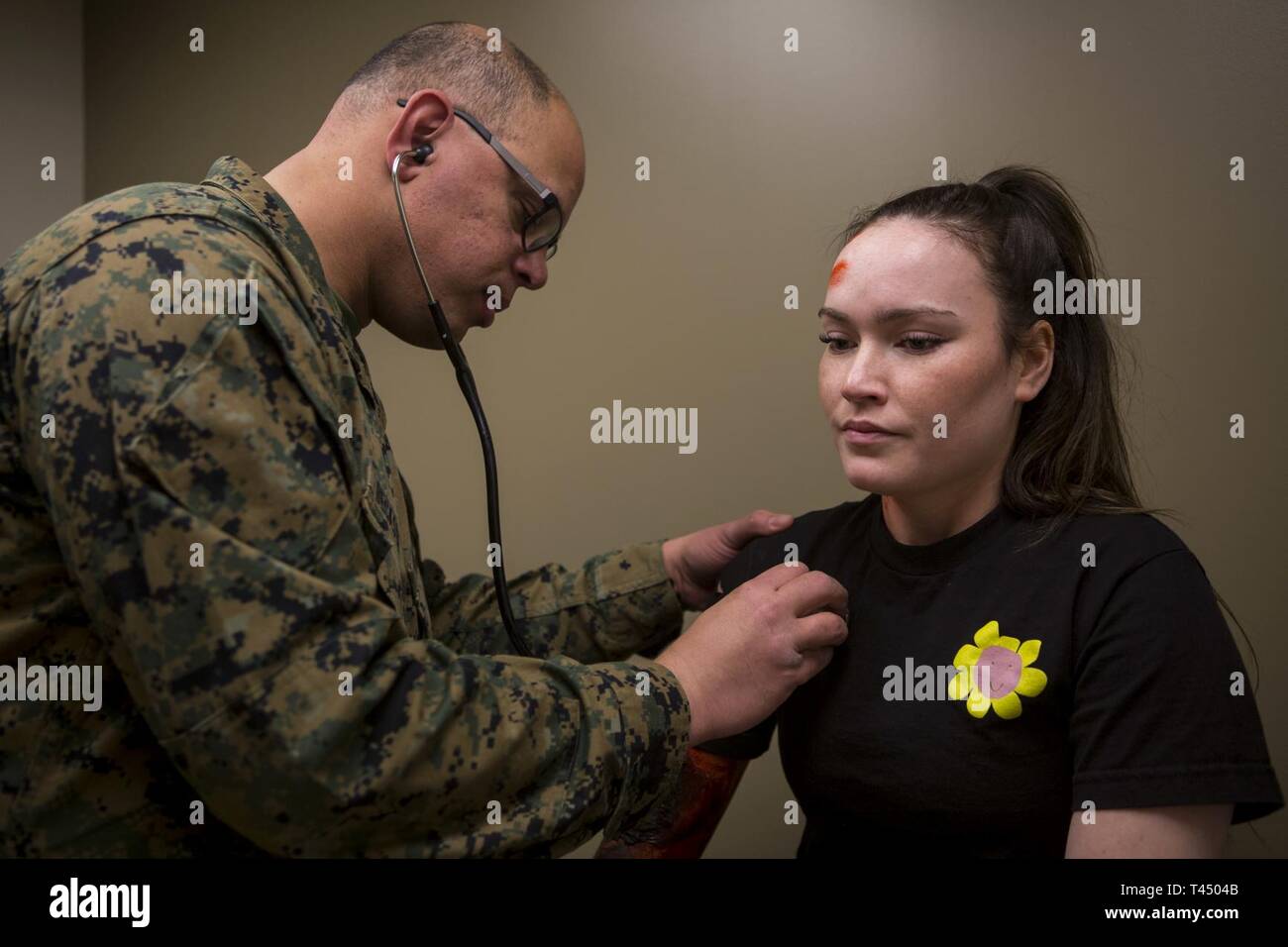 A Sailor gives medical attention to a simulated casualty during a ...