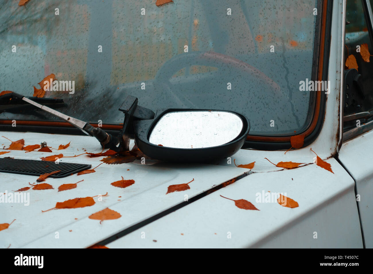 autumn. broken side view mirror is on the hood of an old car. concept ...