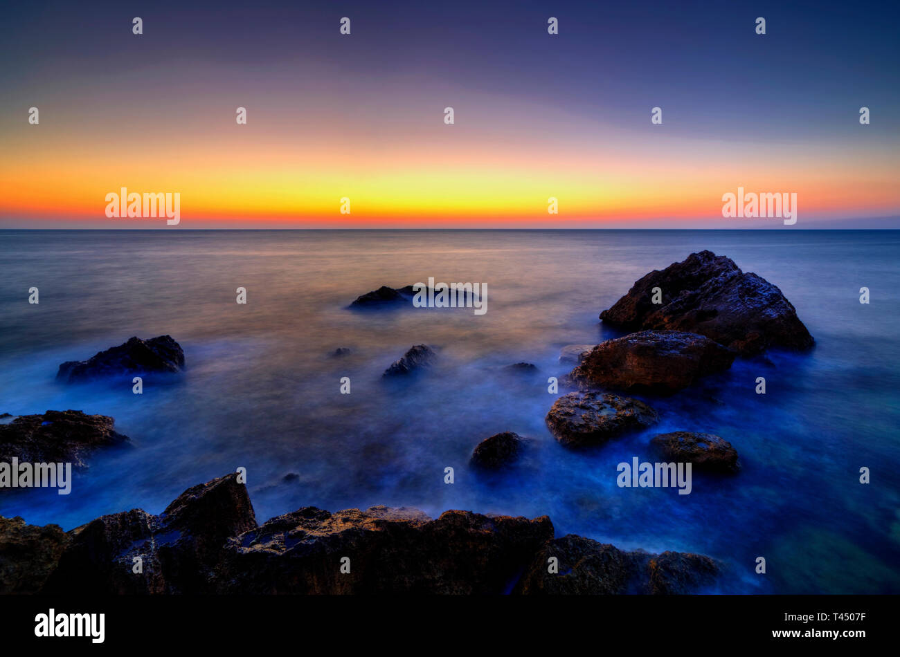 Beautiful sunrise over rocky shore Stock Photo - Alamy