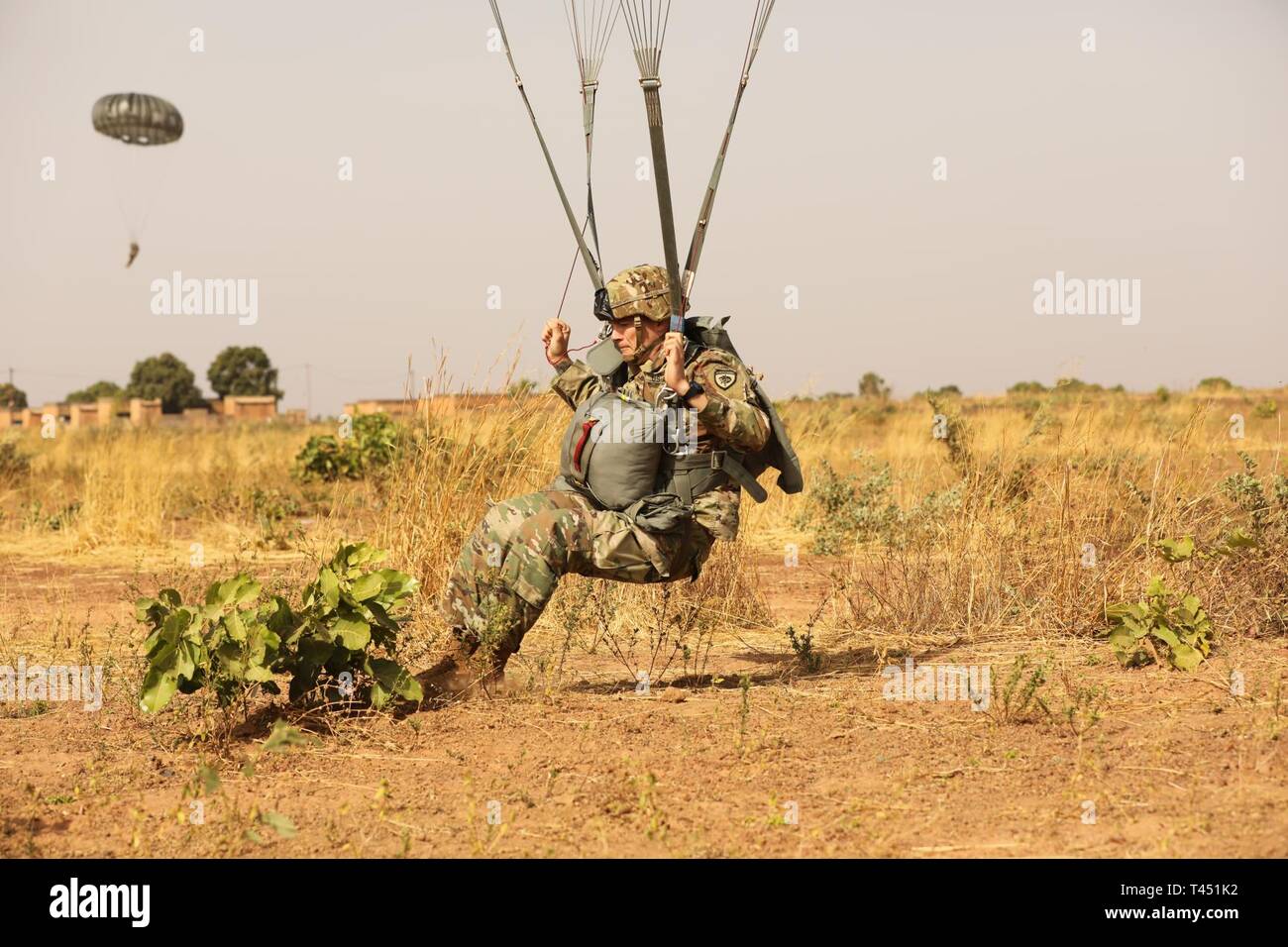 U.S. Army soldier conducts a parachute landing fall at a drop zone at ...