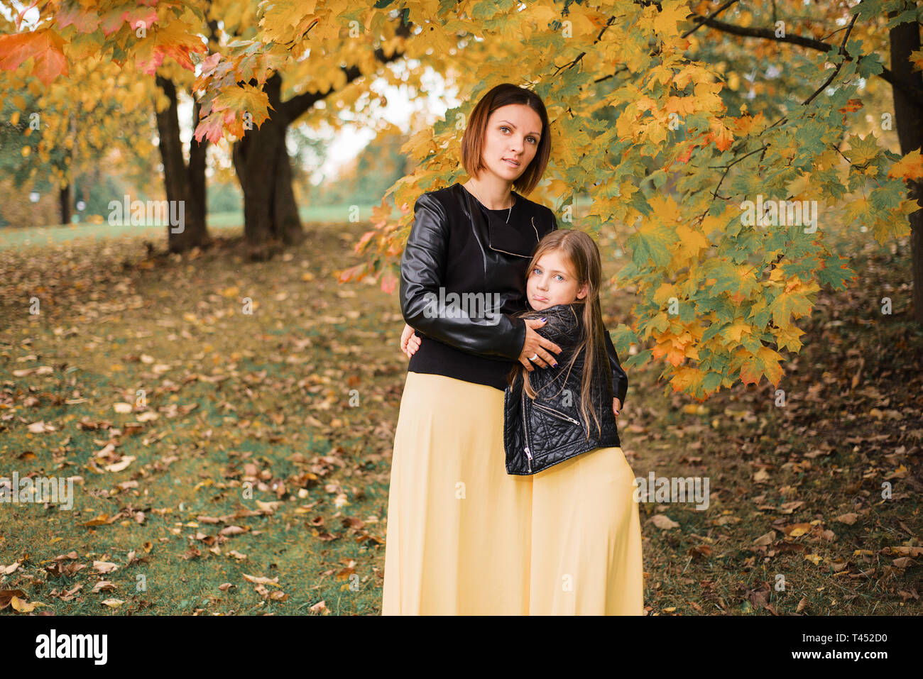 autumn family portrait. mother hugging her daughter near the trees in the park Stock Photo - Alamy