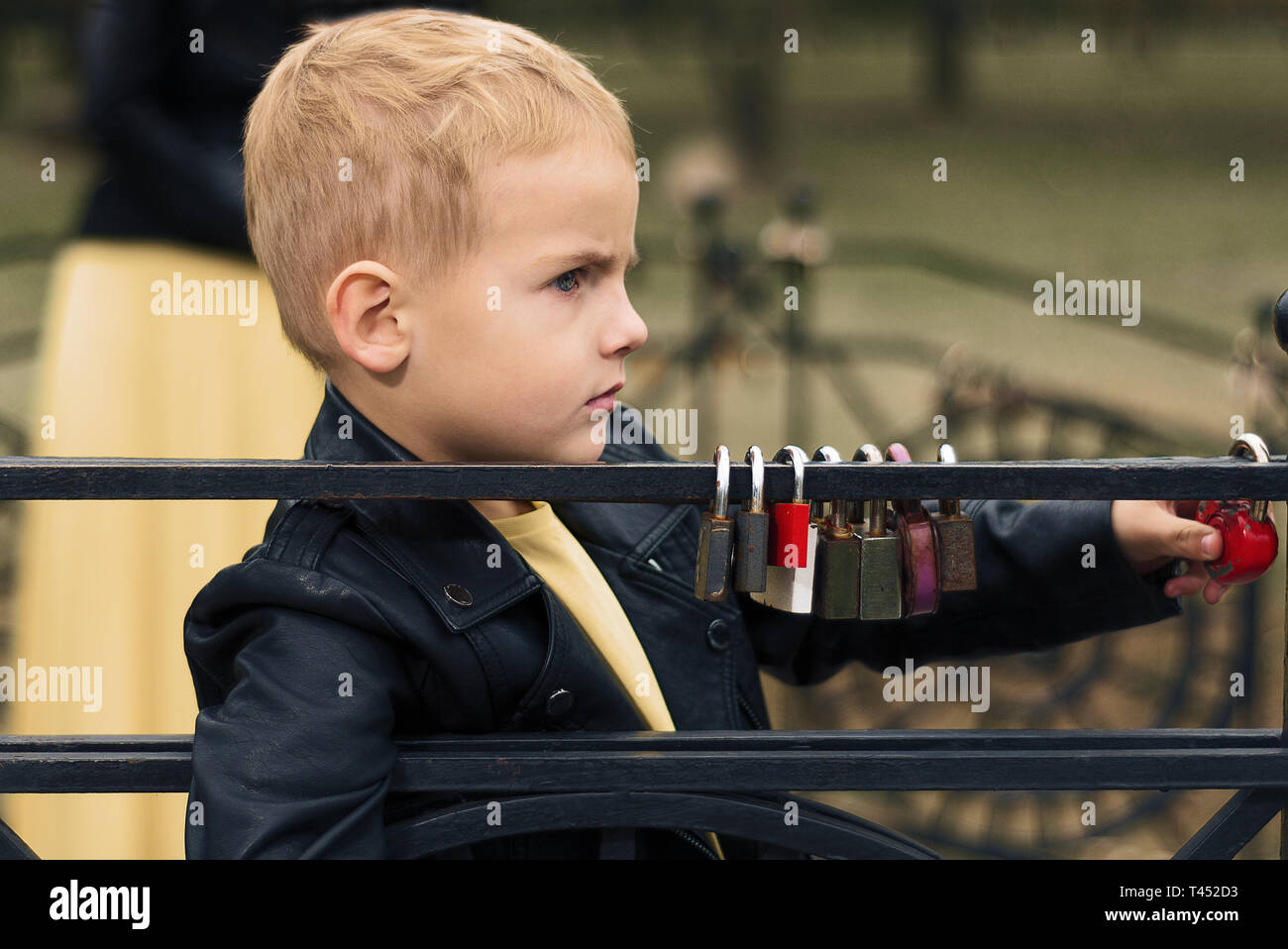 portrait of very serious little boy. child in black leather jacket is ...