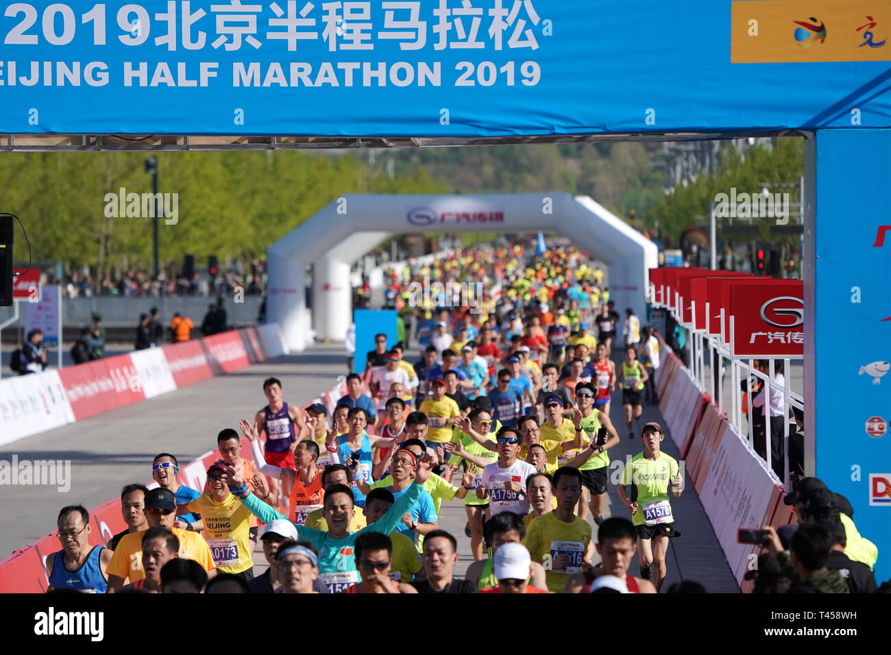 Beijing, China. 14th Apr, 2019. Participants cross the finish line ...