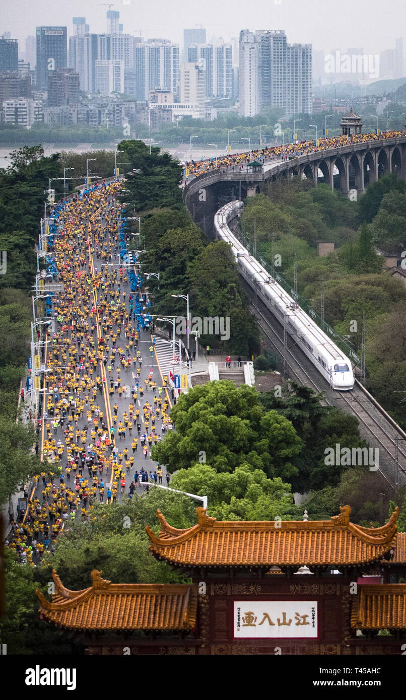 Wuhan, China's Hubei Province. 14th Apr, 2019. Participants run past ...
