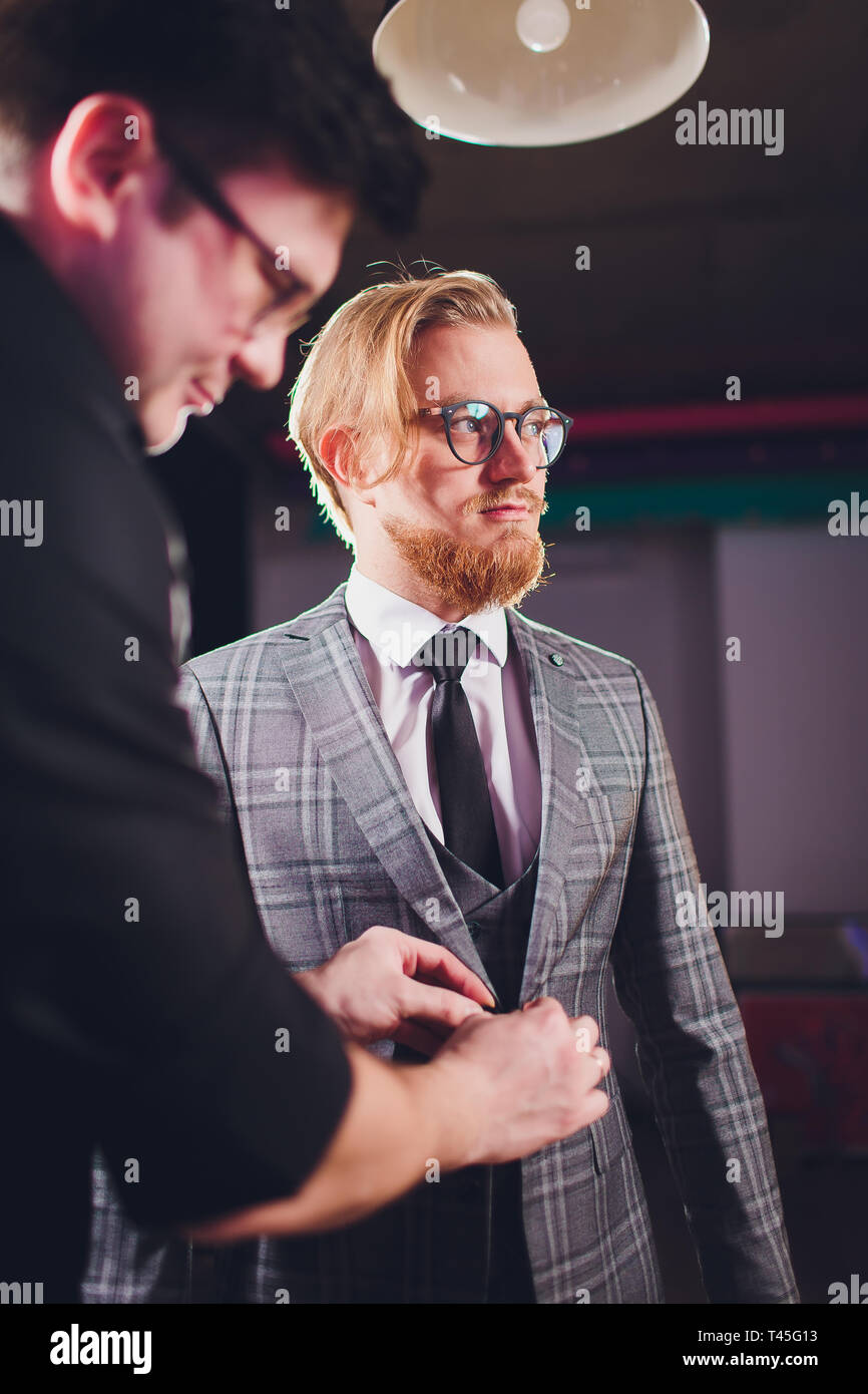 Mature professional Tailor taking measurements for sewing suit at ...