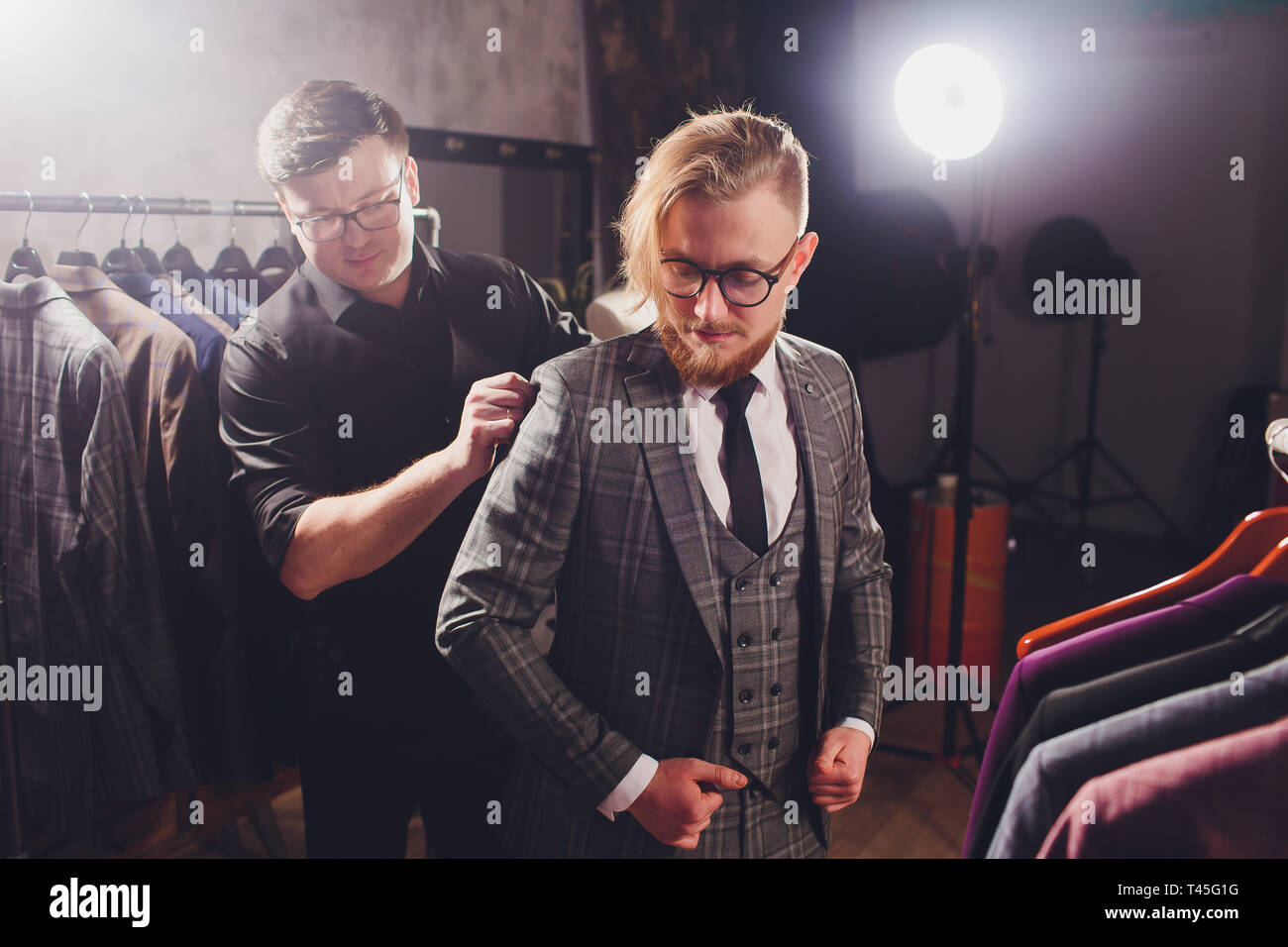 Mature professional Tailor taking measurements for sewing suit at ...