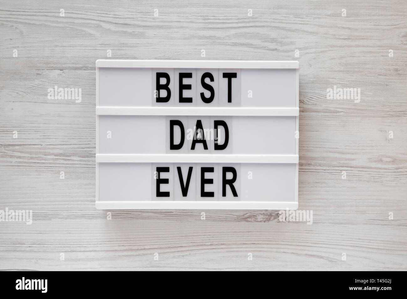 'Best dad ever' words on modern board over white wooden background, top ...
