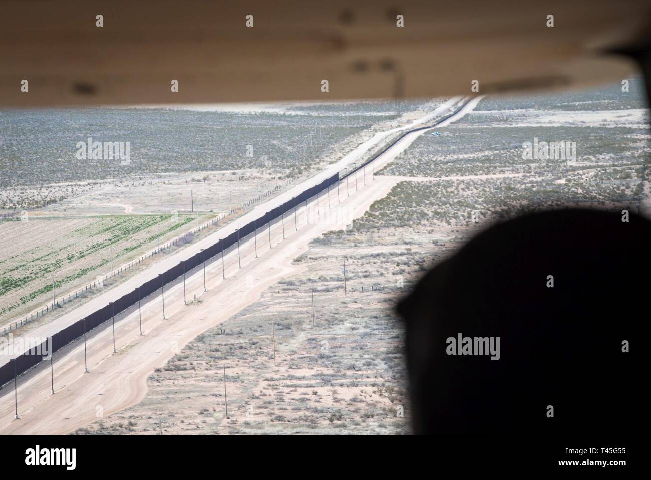 An older section (top right) of the border fence meets a newer section ...