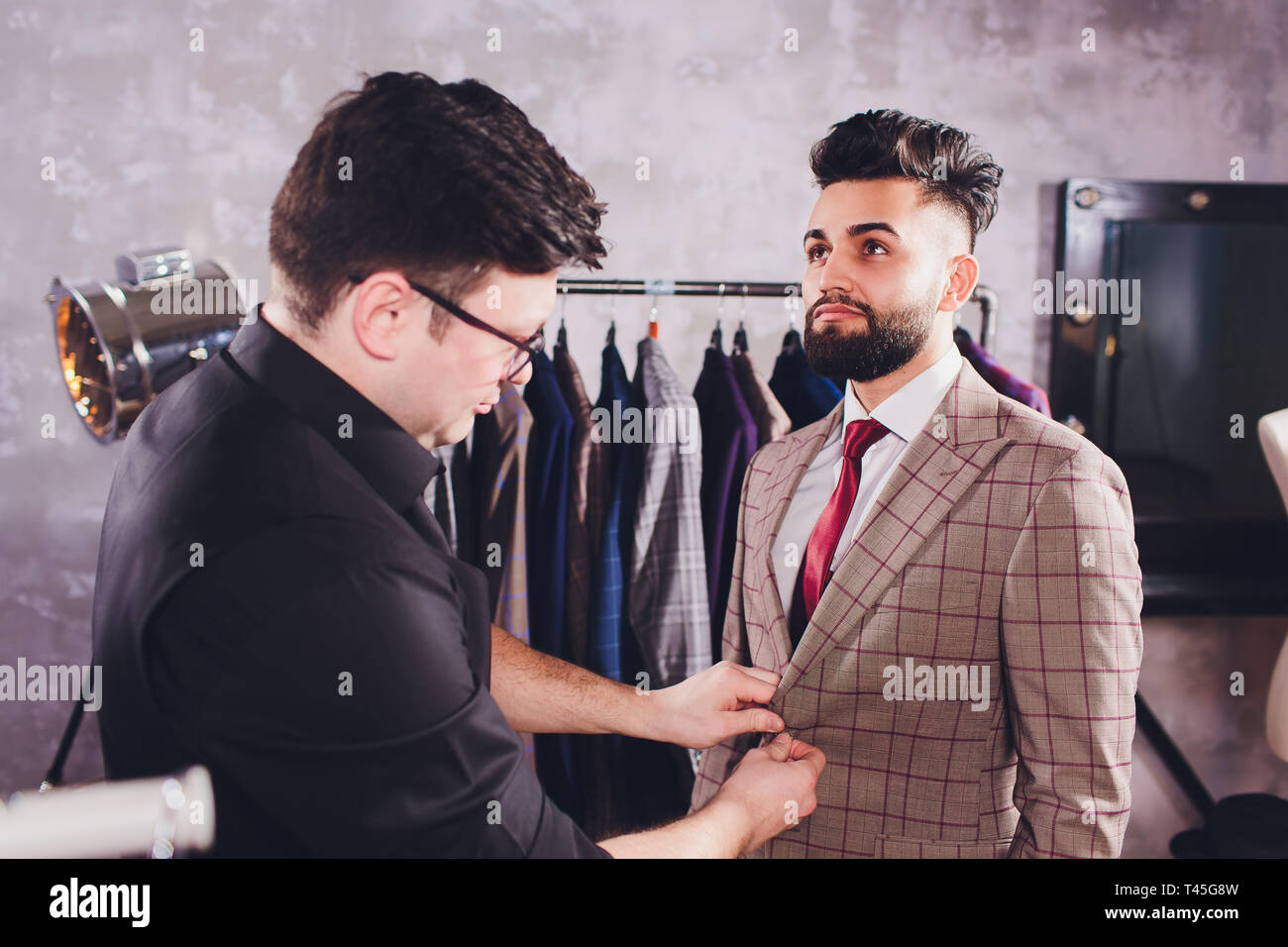 Mature professional Tailor taking measurements for sewing suit at ...