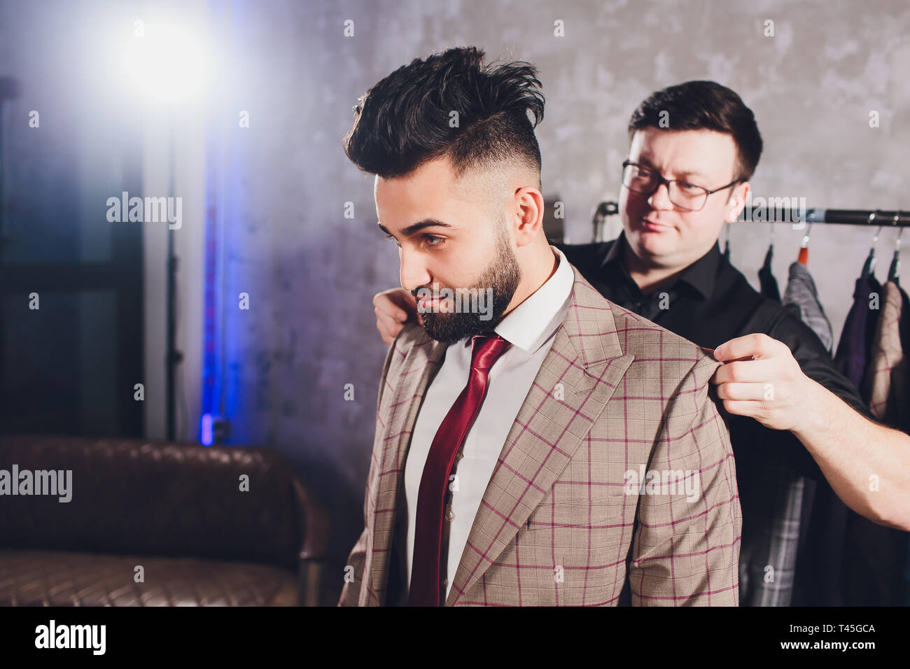 Mature professional Tailor taking measurements for sewing suit at ...