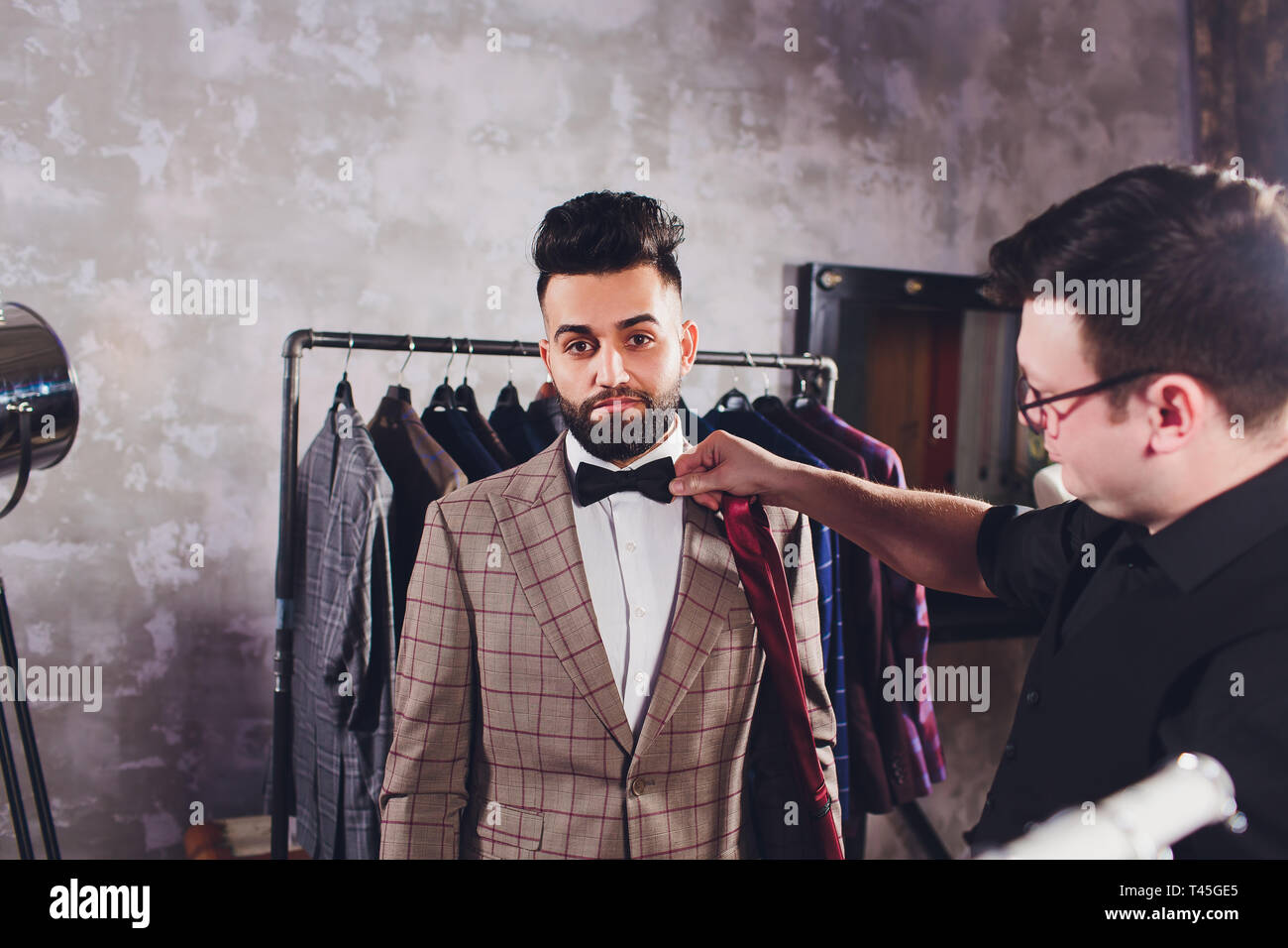 Mature professional Tailor taking measurements for sewing suit at ...