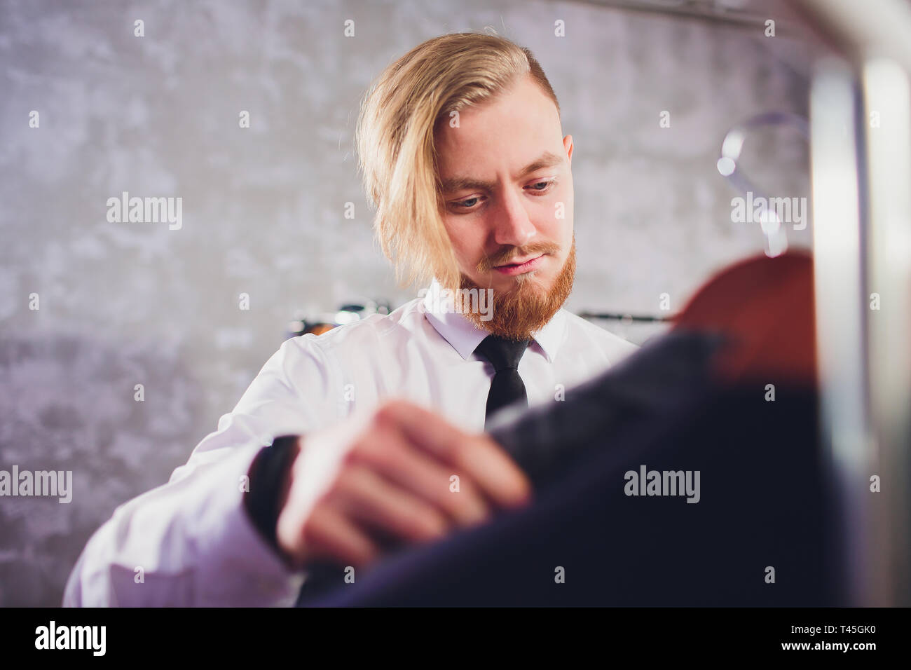 portrait of male client choosing classic jacket in the mall Stock Photo ...