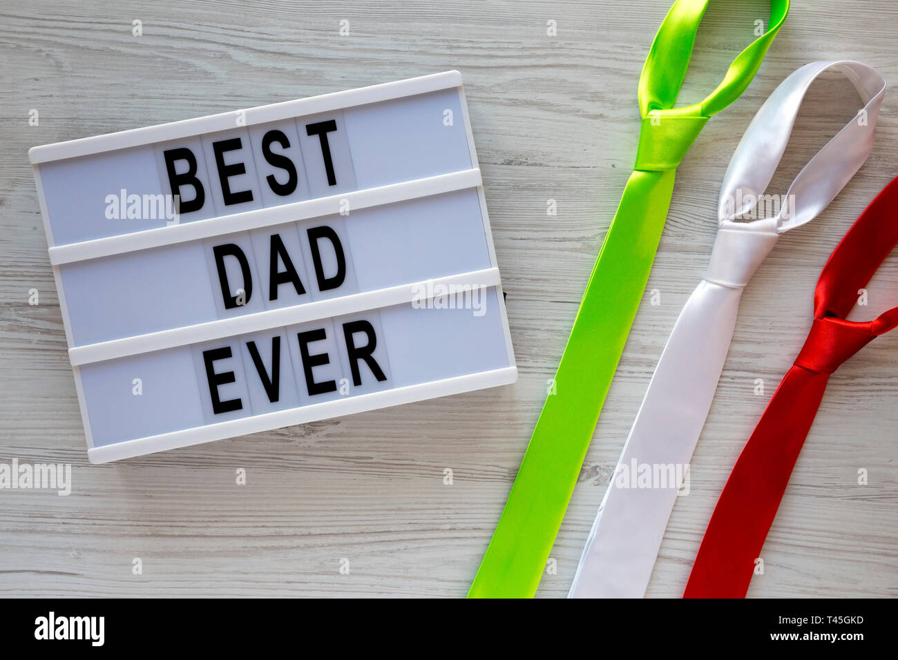 'Best dad ever' words on lmodern board, colored ties over white wooden ...