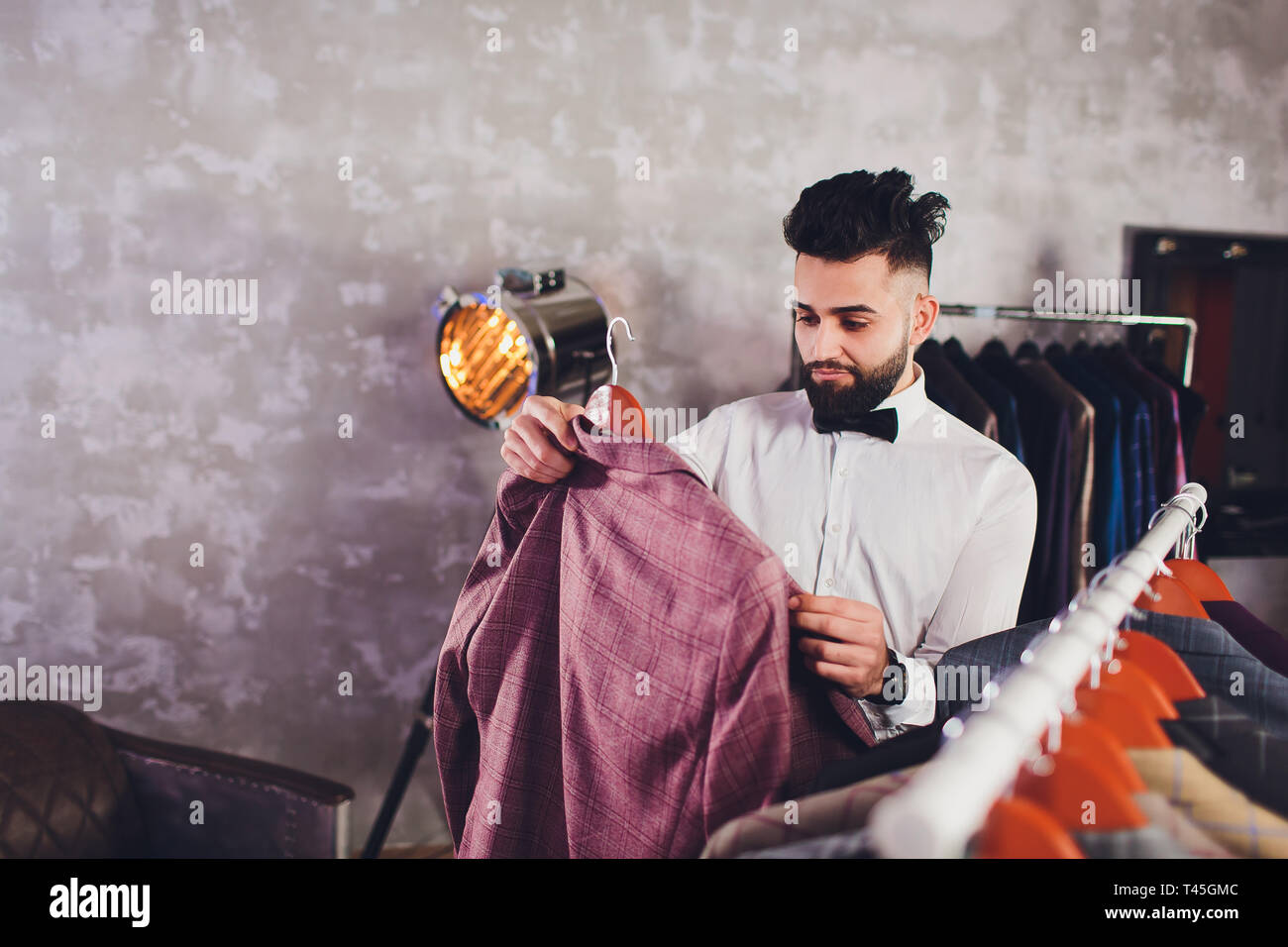 Positive guy customer looking jacket in men clothes store Stock Photo ...