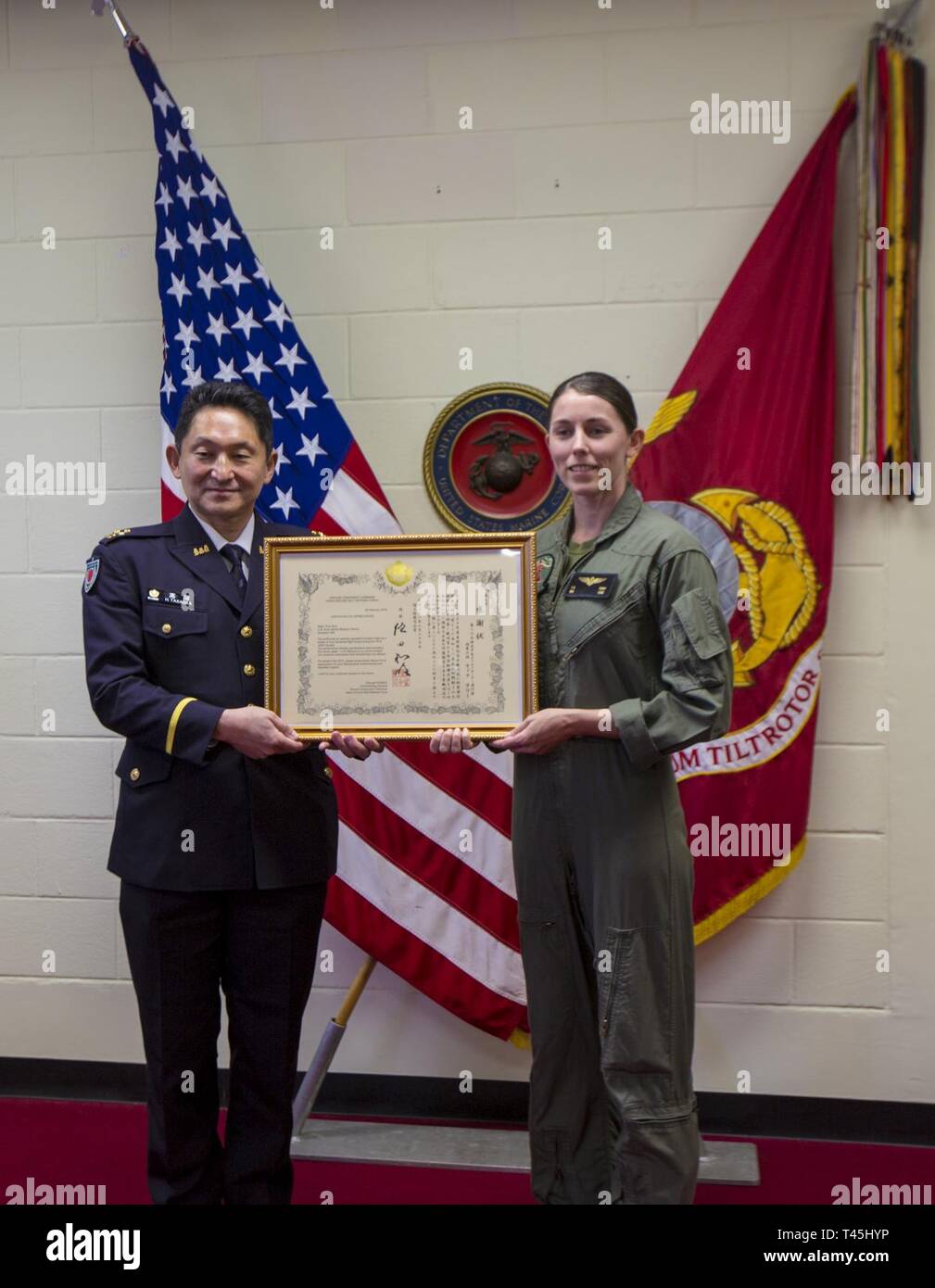 Colonel Takaoka (left) presents Maj. Tina D. Terry (right) with a ...