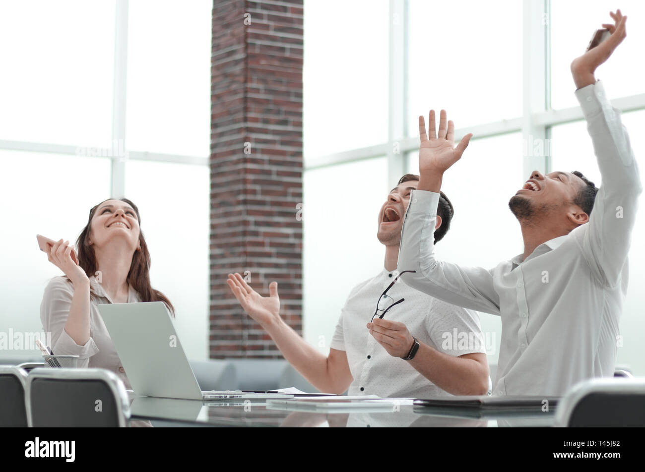 Happy business team celebrates business success in a bright office ...