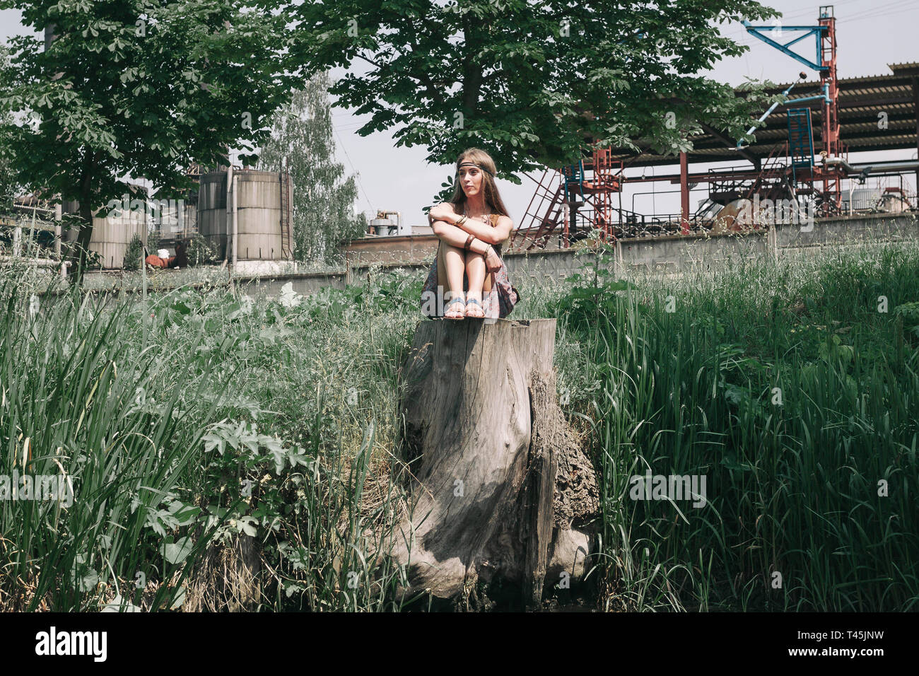 young hippie woman sitting near the pond . the concept of unity with ...