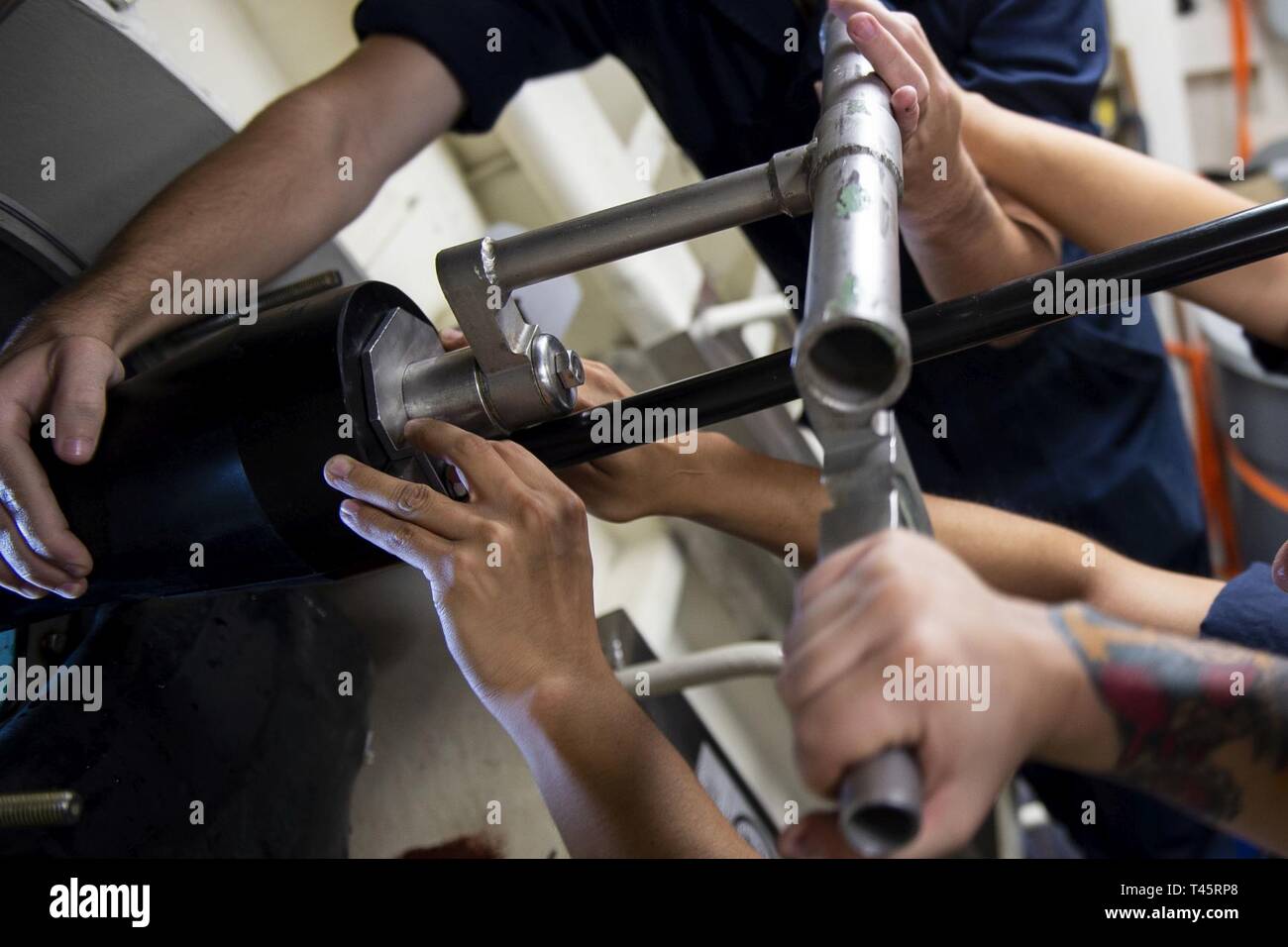 U.S. Navy Sailors connect a plug pipe assembly to a Multi-Function ...