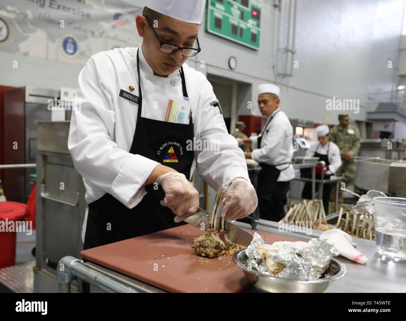 Spc. Daniel Badillo, culinary arts specialist, Fort Bliss, Texas, cuts ...