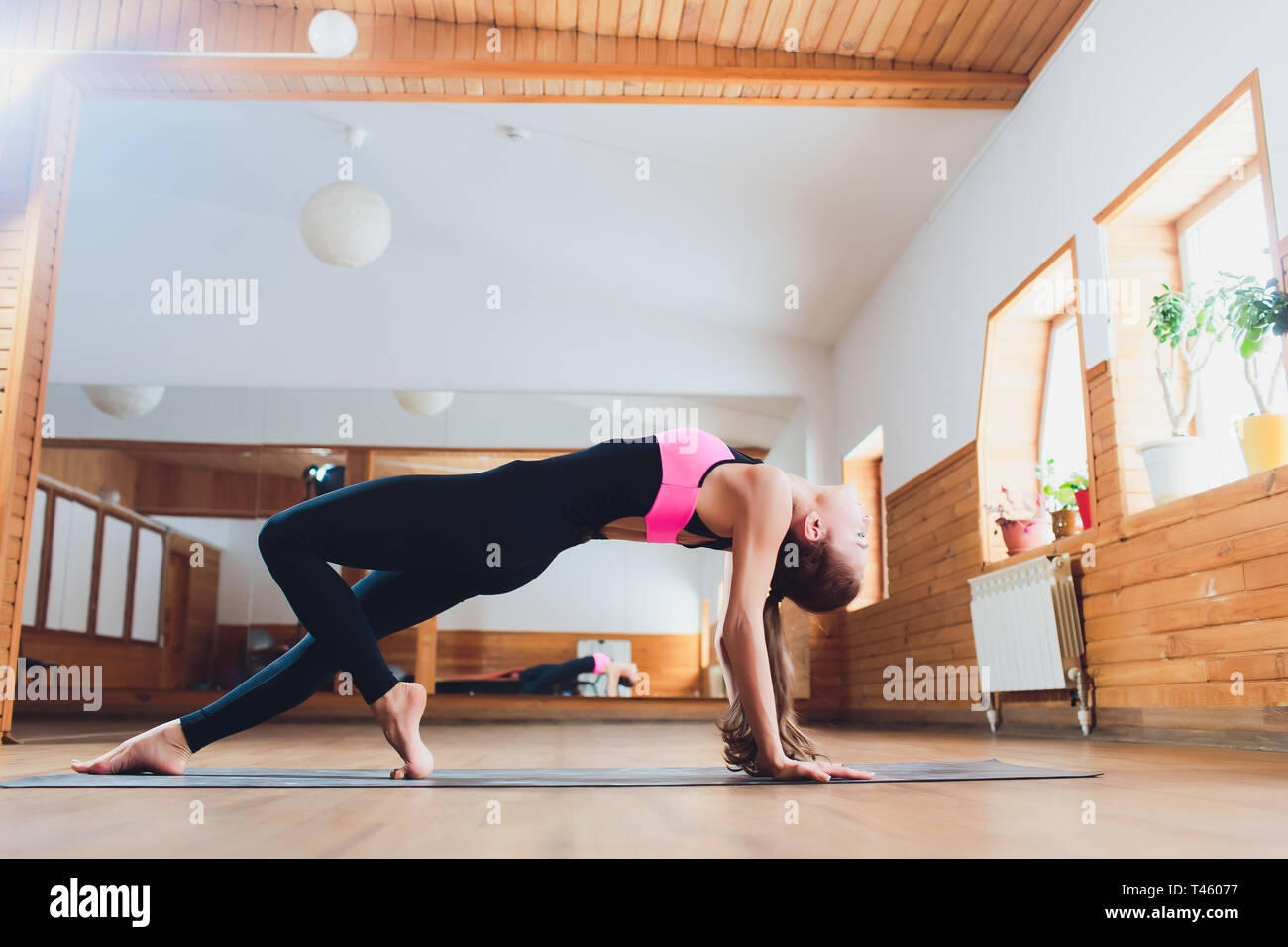 Young woman practicing yoga, stretching in variation of Reverse Table ...