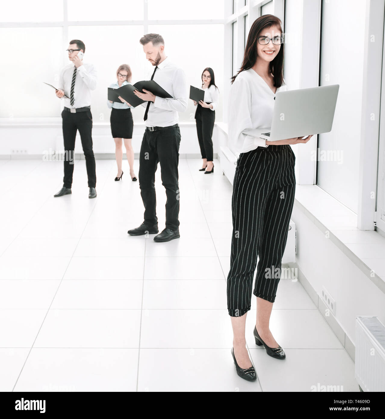 employees of the company standing in a spacious office lobby. photo ...