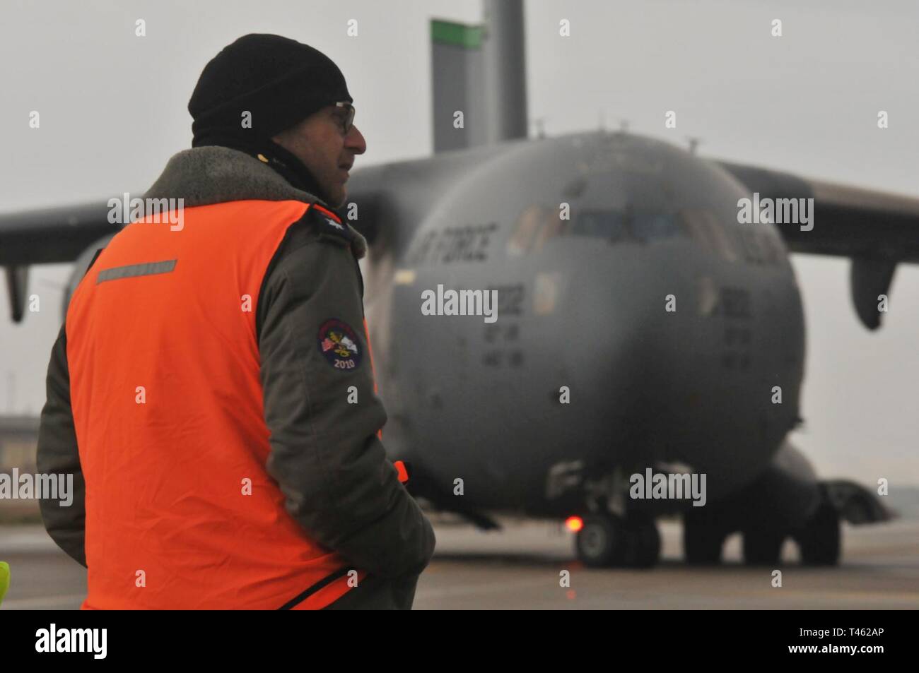 An Israeli service member watches as a C-17 Globe Master III lands at ...