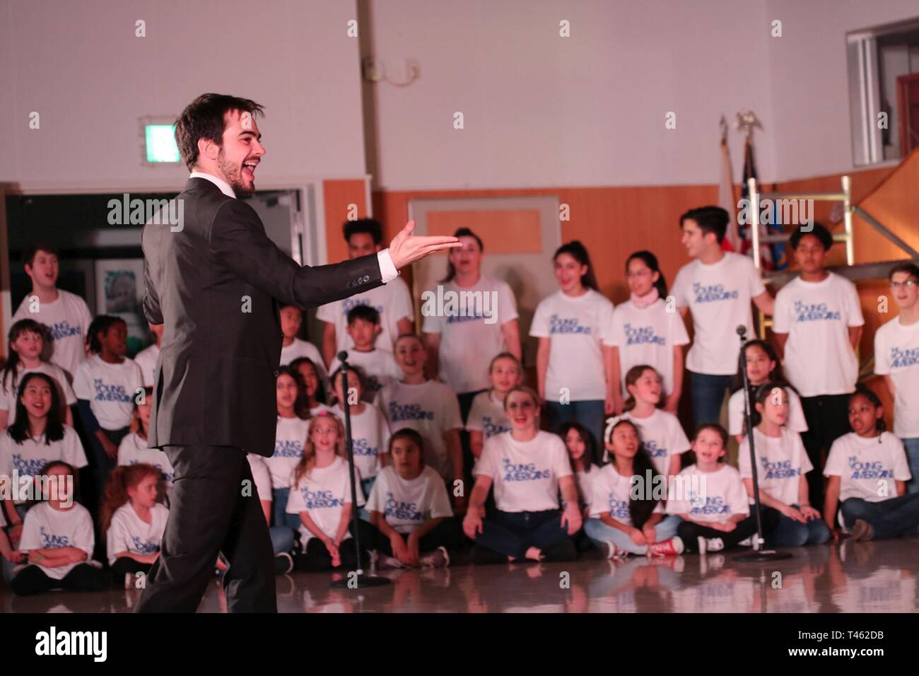 Nathan Schneider, guest director for Young Americans, conducts the cast ...