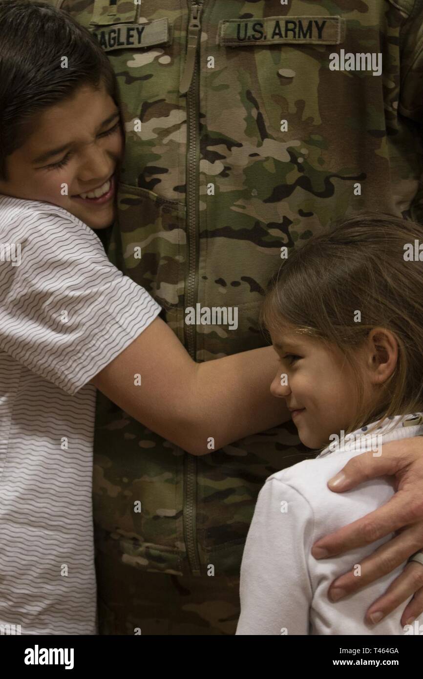 Seth and Karly Dagley, 10 and 7, embrace their father, Warrant officer ...