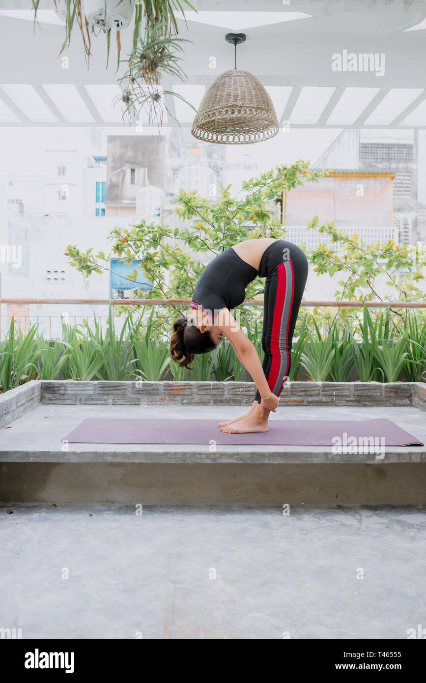 Young asian woman in relaxation stretching position on her balcony ...