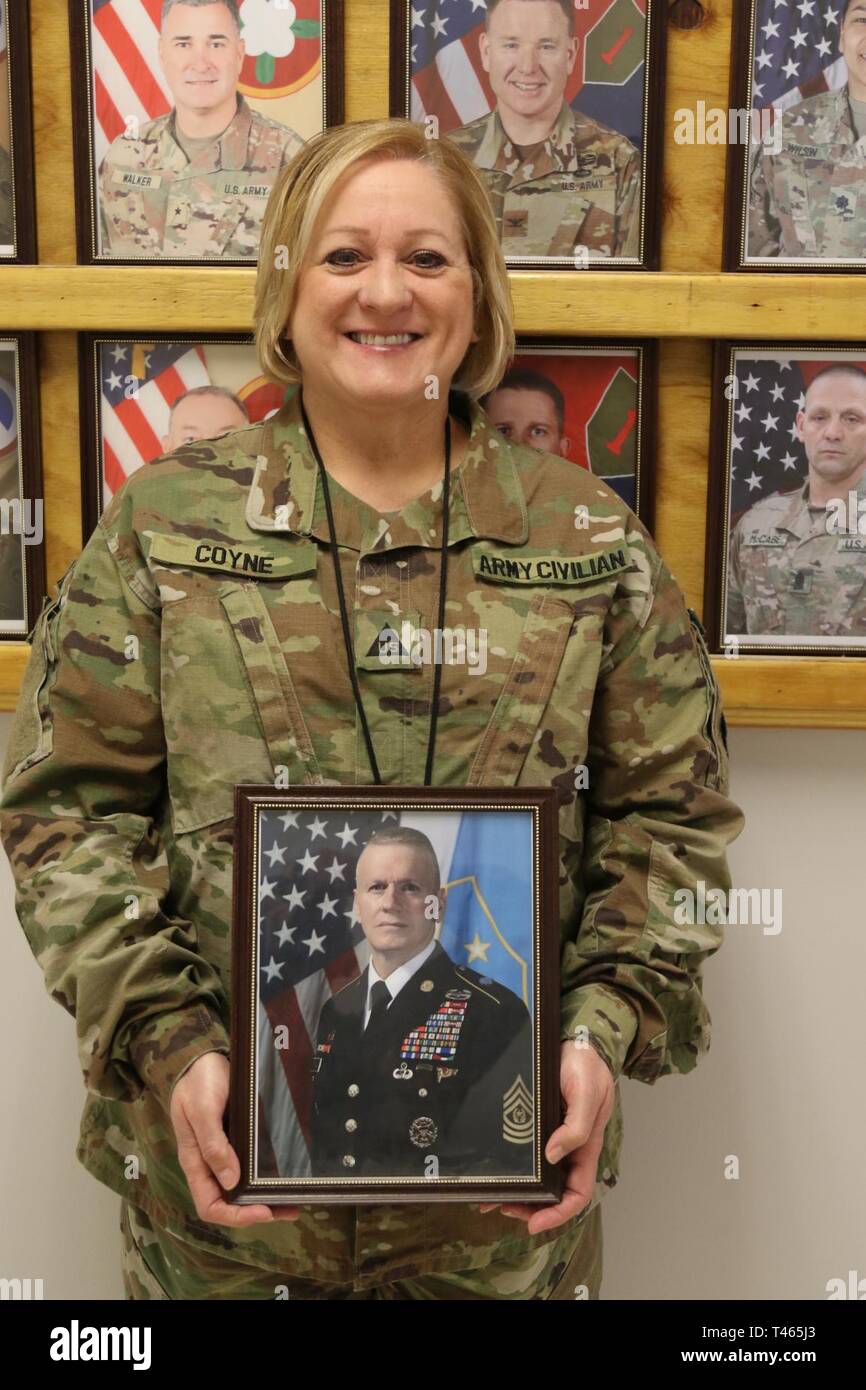 Department of the Army Civilian Ms. Patricia Coyne holds a photo of her ...