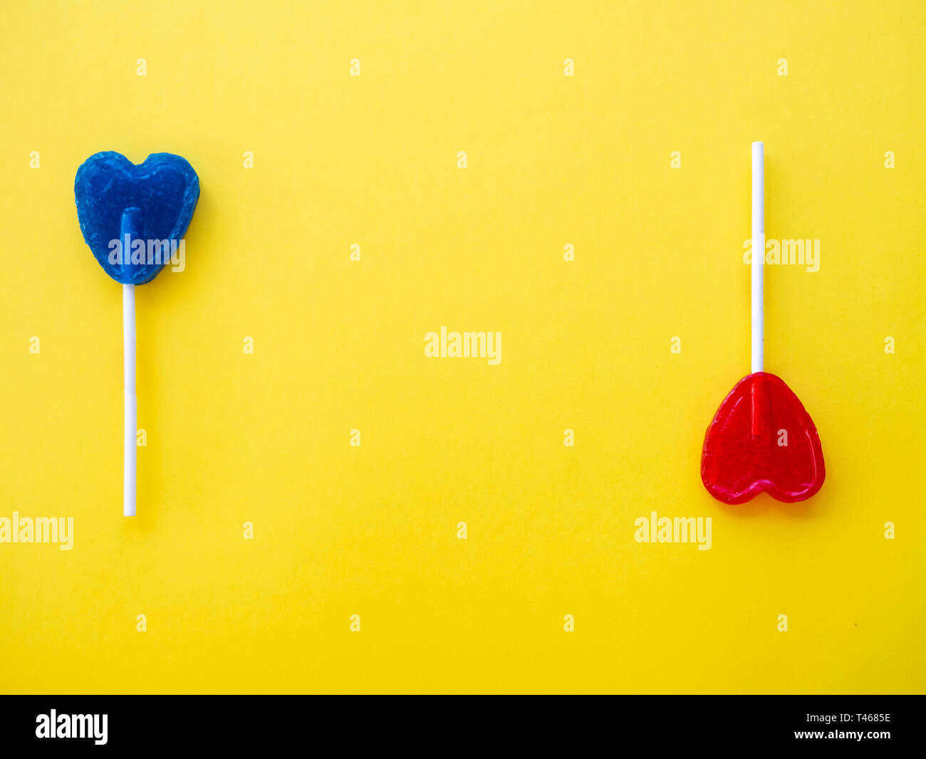 Blue and red lollipop on a yellow background Stock Photo - Alamy