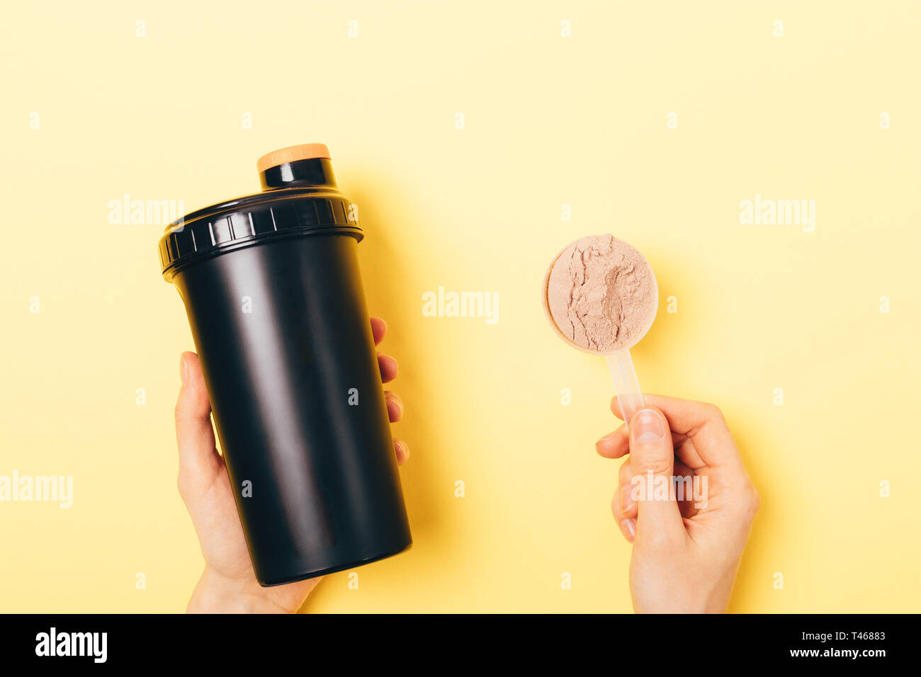 Female's hands holding scoop of whey protein powder and shaker for ...