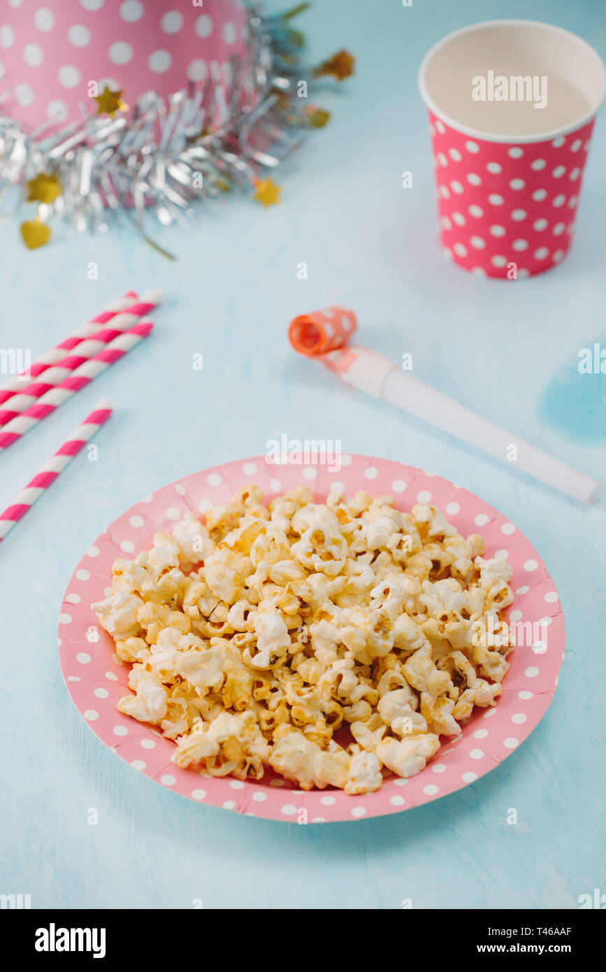 Birthday party items with popcorn on table Stock Photo - Alamy