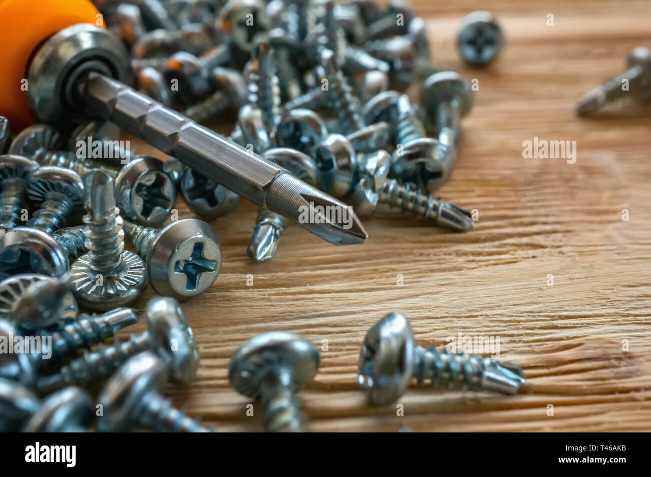 Manual screwdriver screws and dowels on a wood background Stock Photo ...